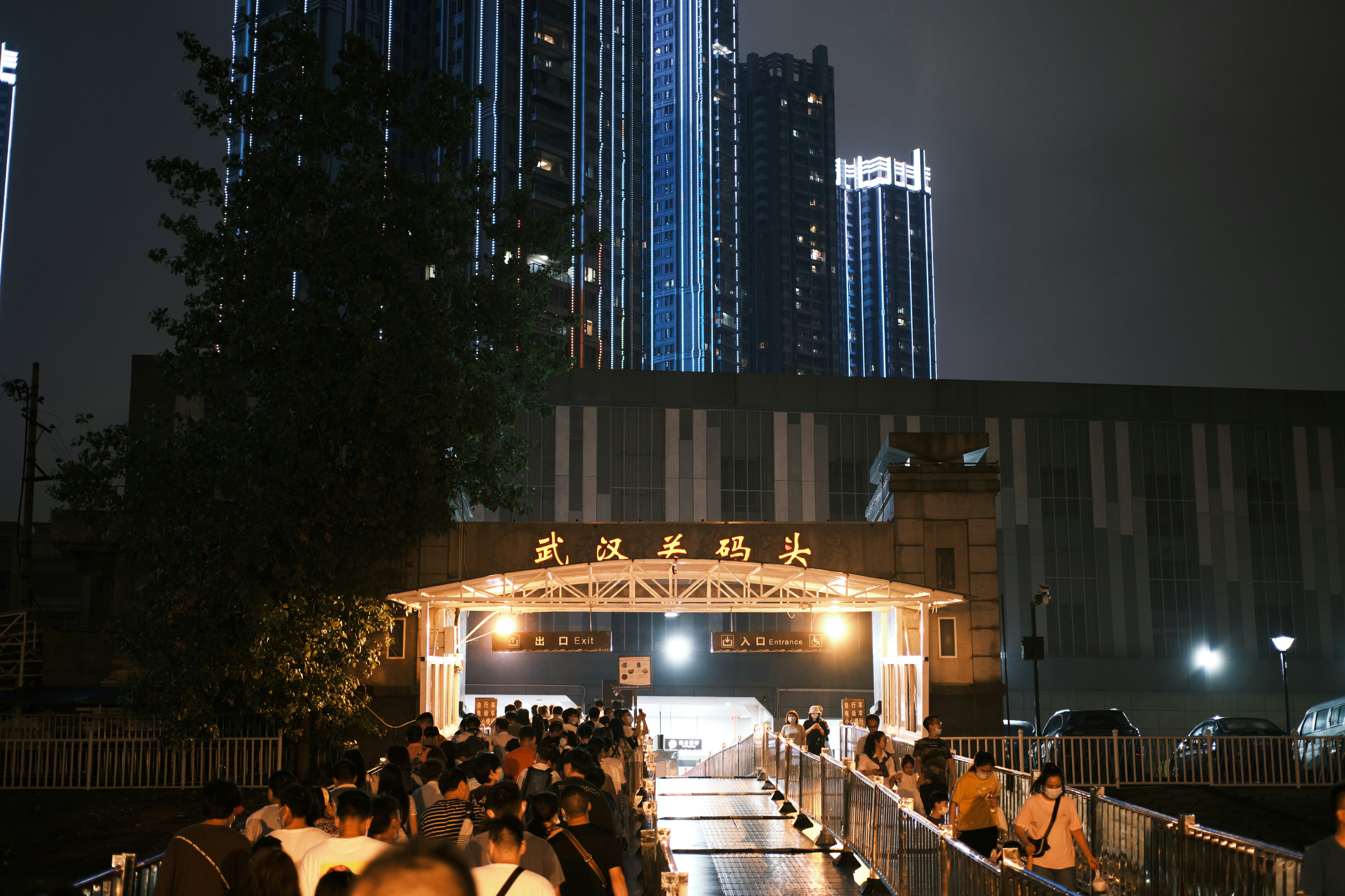 people sitting on white chairs near white concrete building during nighttime
