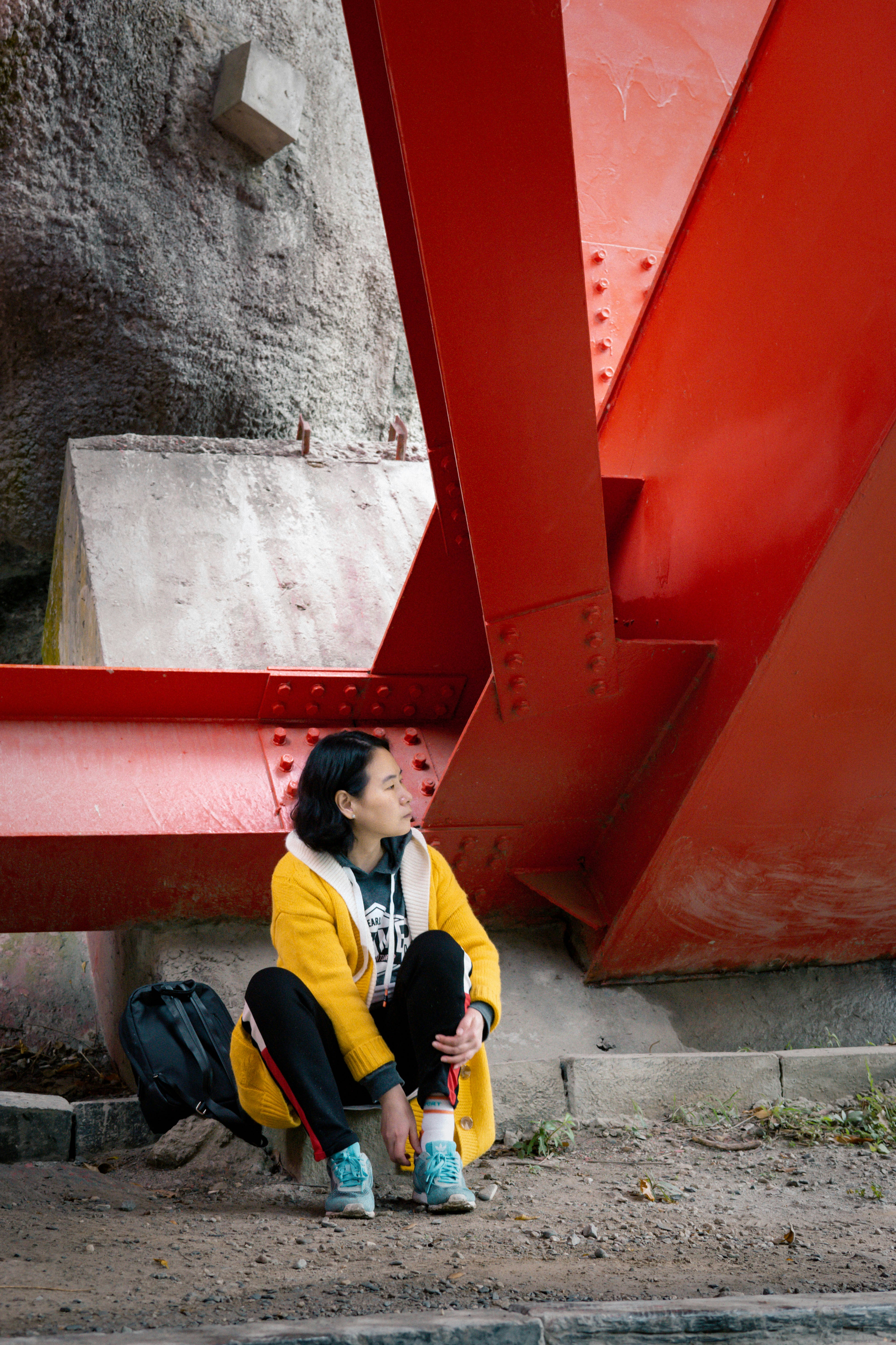 Women adjusting her shoes. Hiking near Hualien in Taiwan. Resting under a bridge. 