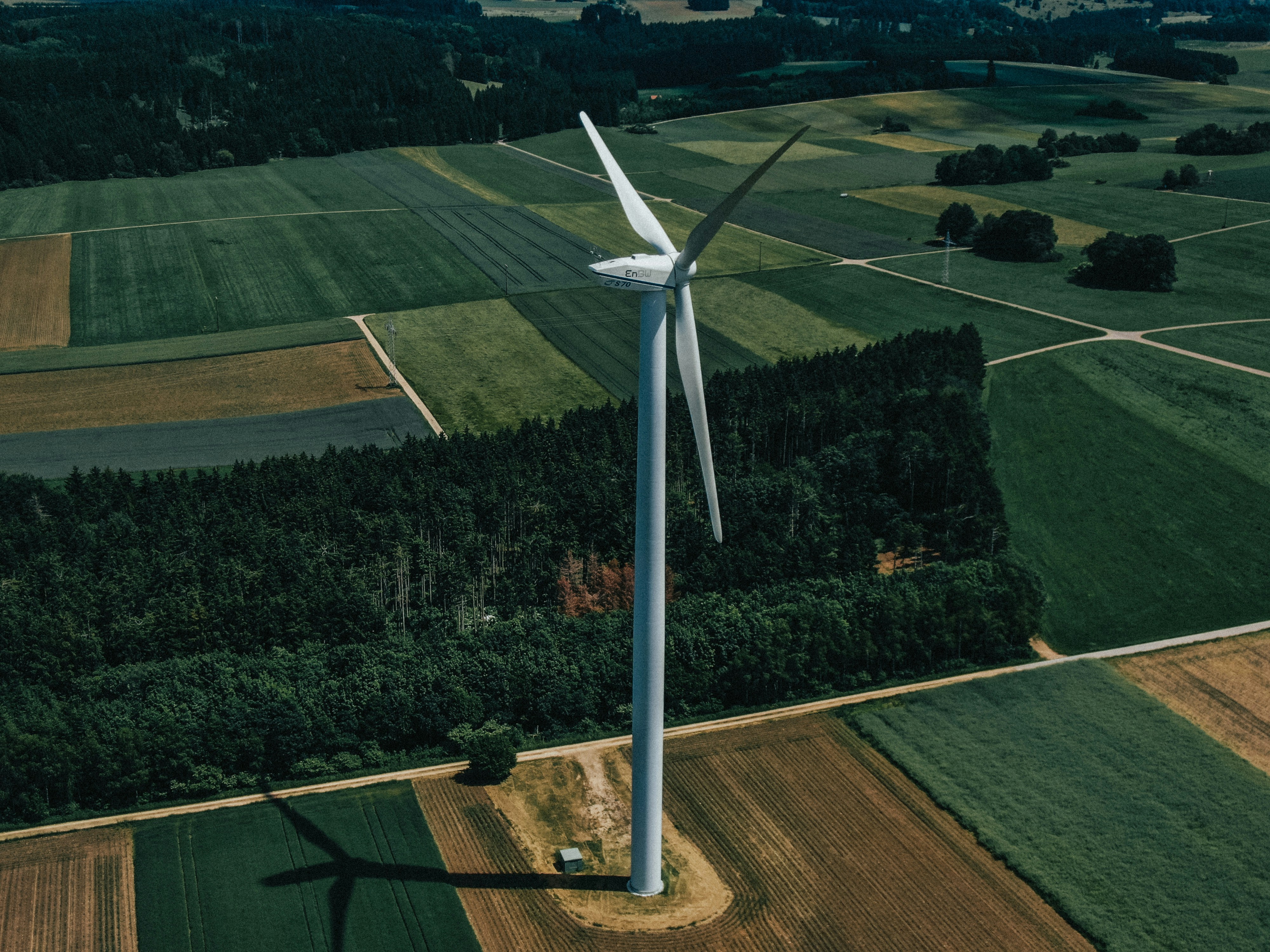 Patchwork Sentinel: A Wind Turbine Standing Over Farmland