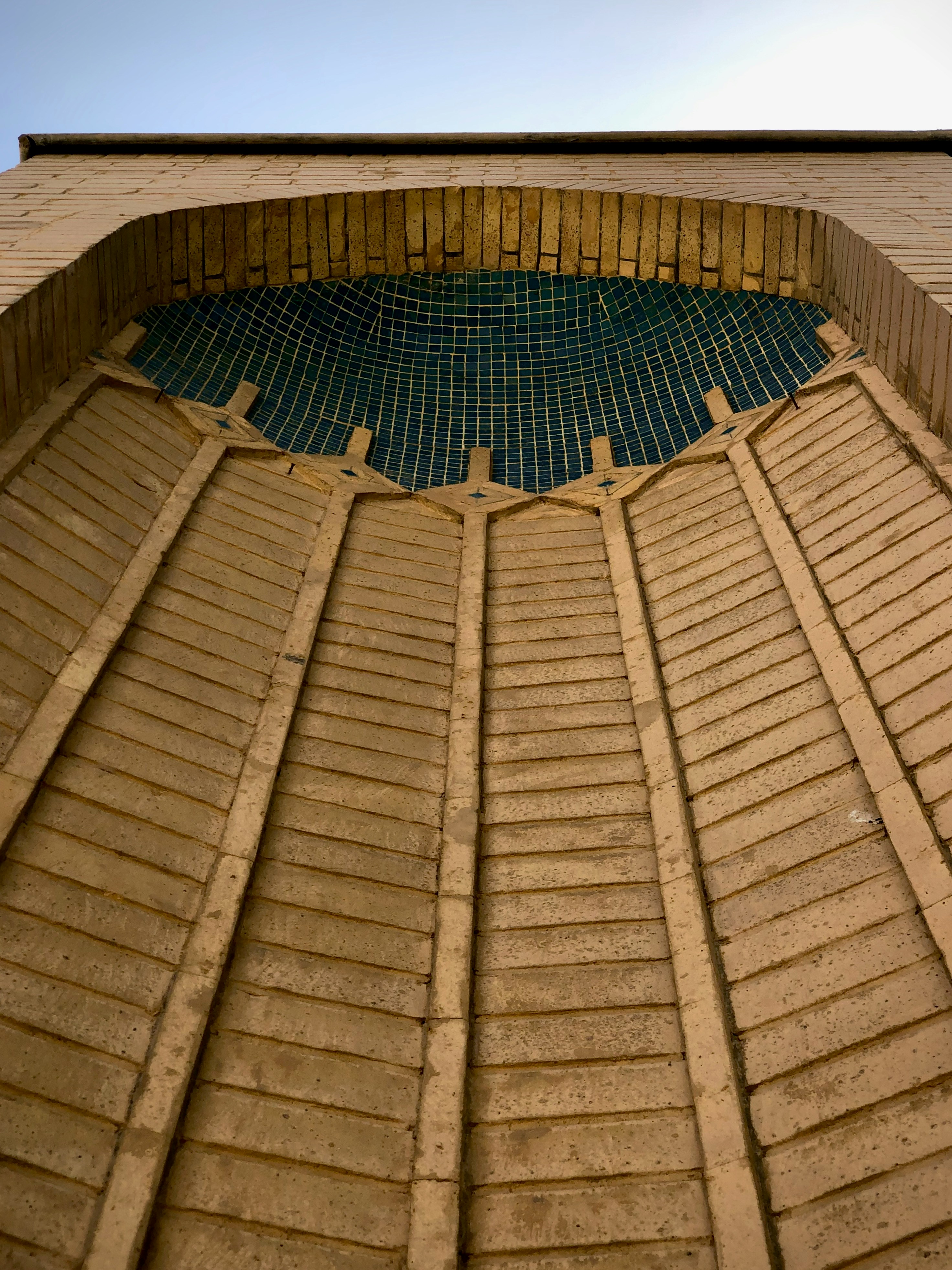 Vertical Rib Arch: Brick Canyon Framing a Blue Tile Window