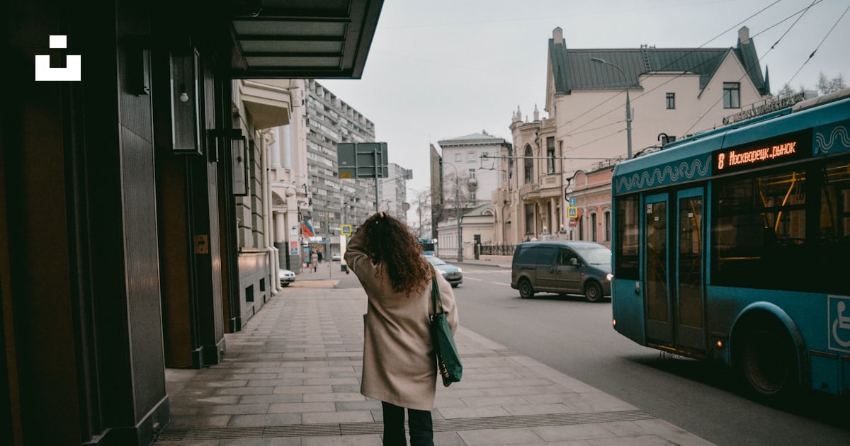 낮 동안 보도를 걷고 있는 베이지색 코트를 입은 여자 사진 Unsplash의 무료 모스크바 이미지