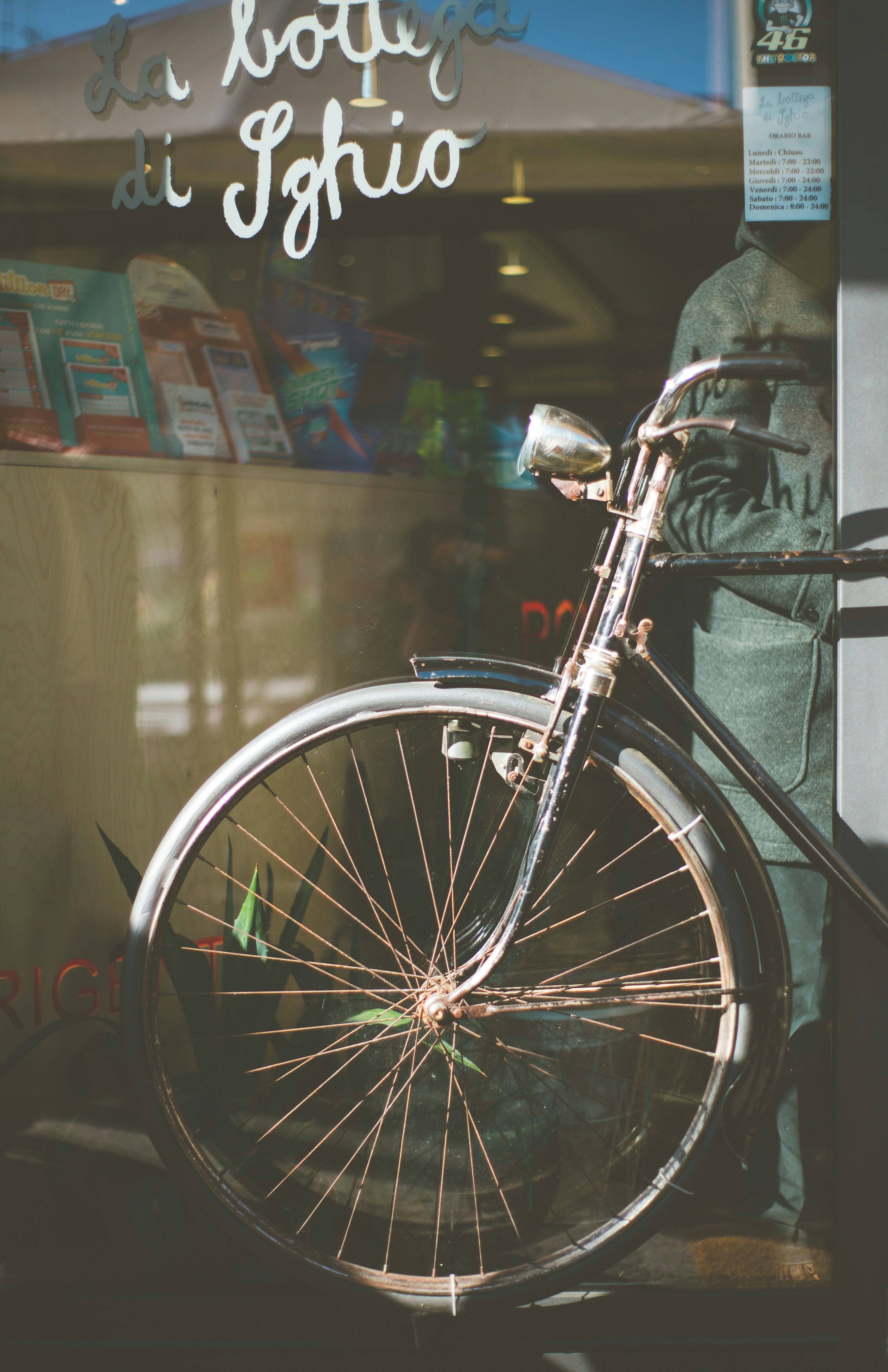 The Front Wheel of Time: A Vintage Bike Framed in a Coffee Shop Window