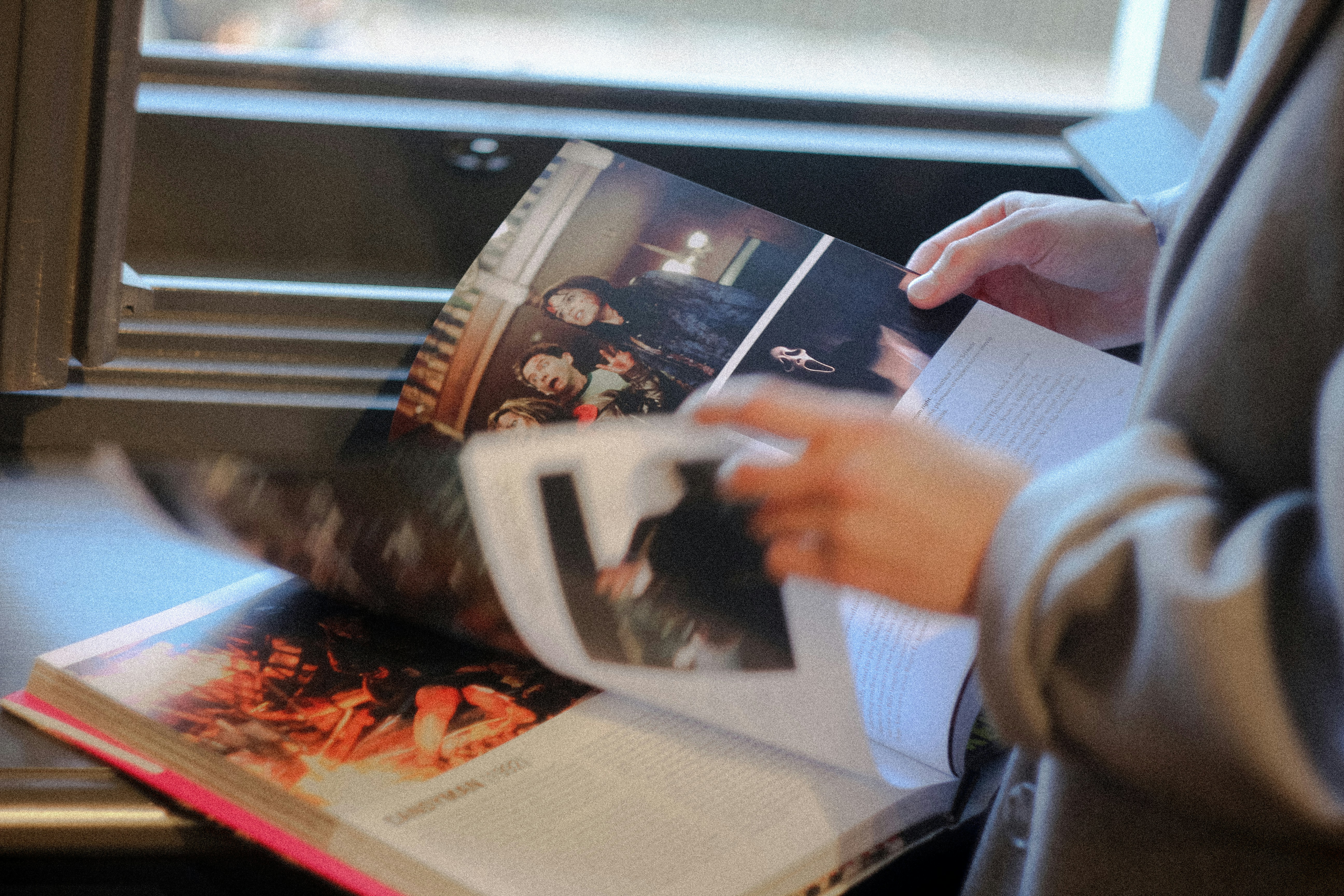 Hands of a girl in an overcoat flipping through a magazine. Image from the movie "Scream"