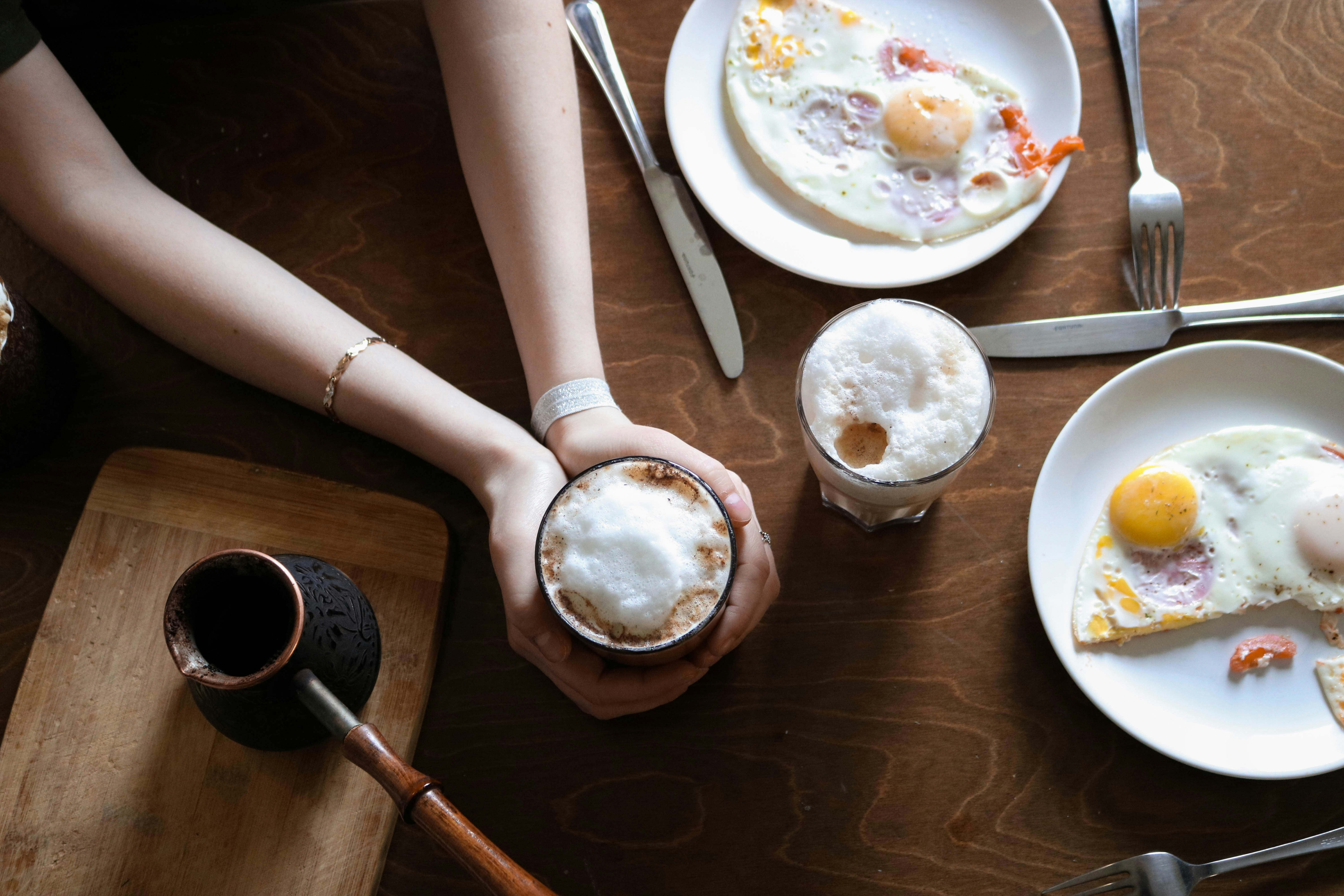 Froth and Focus: Brunch Framed by Hands and Foam