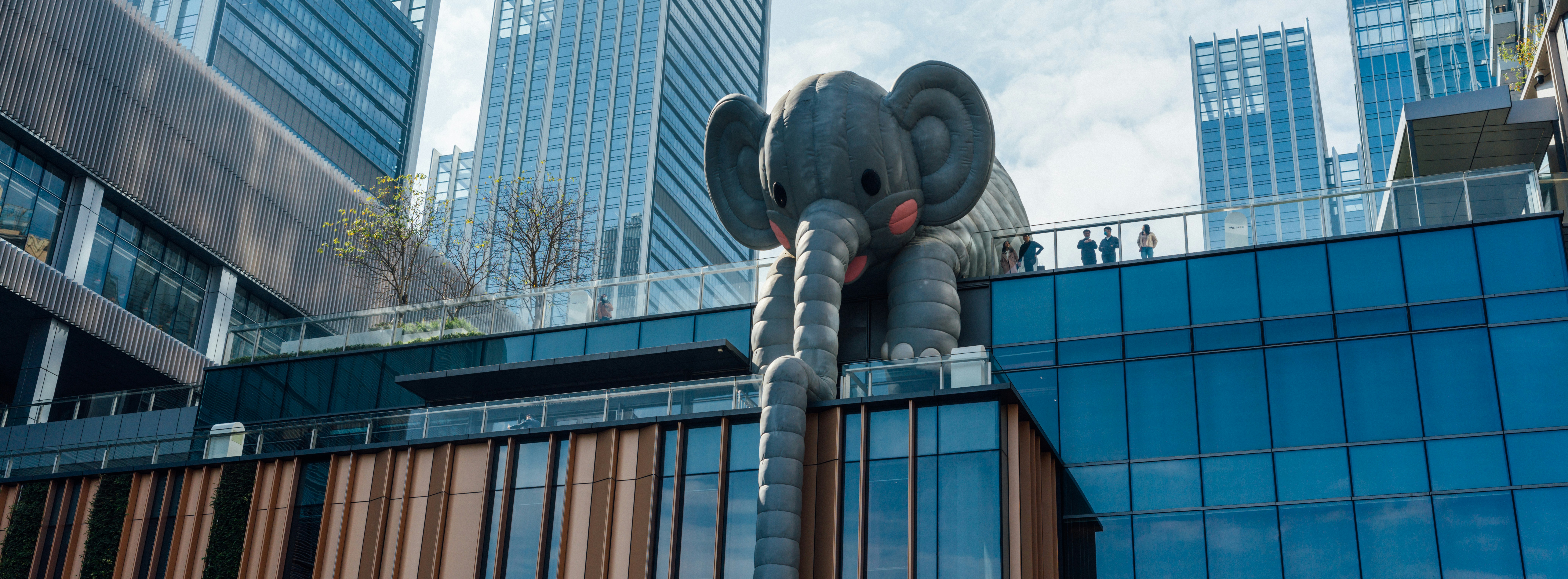 Urban Colossus Over the Glass: A Giant Elephant Treads the Skyline