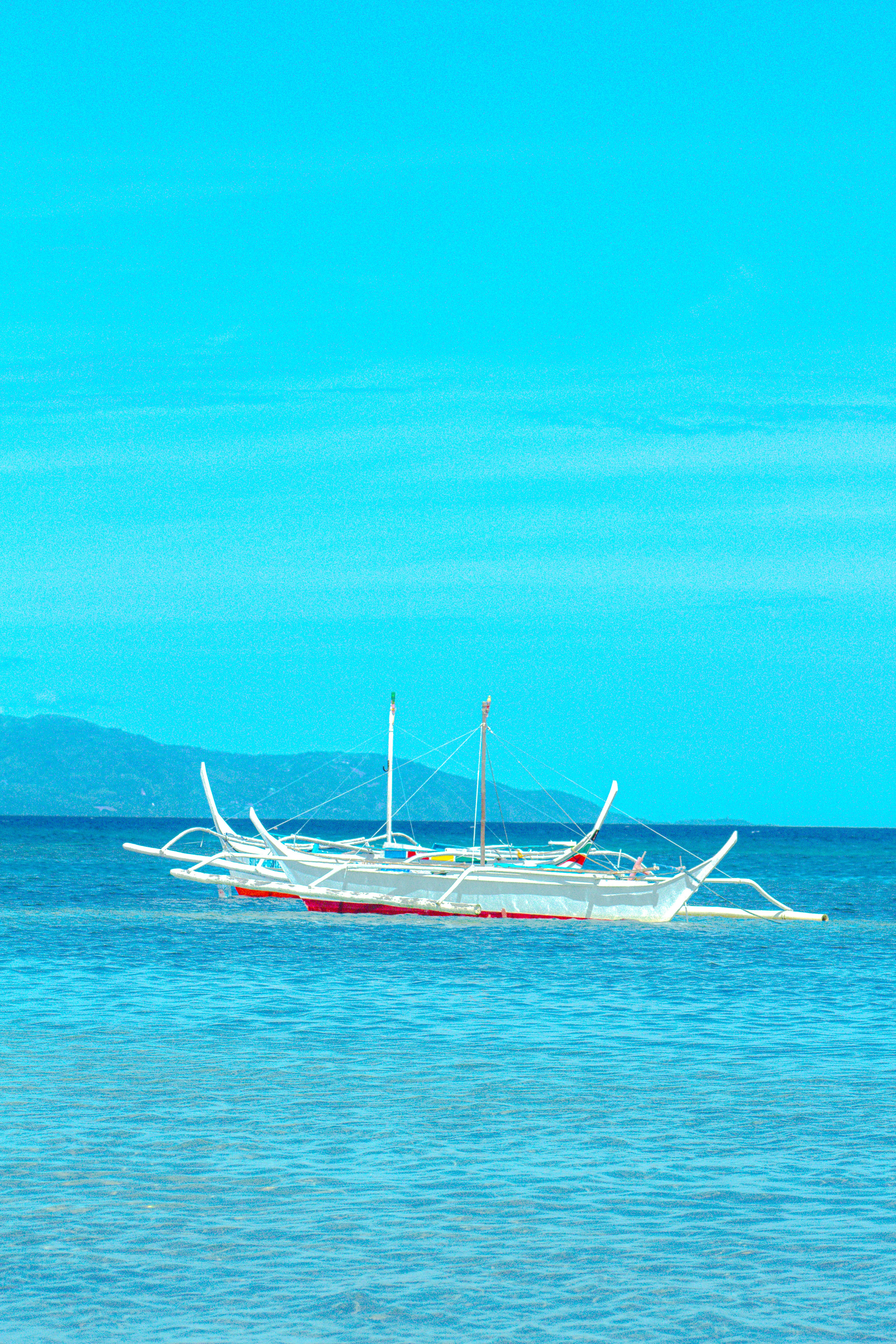 Azure Hulls at Rest: Outriggers Quietly Punctuate the Turquoise Sea