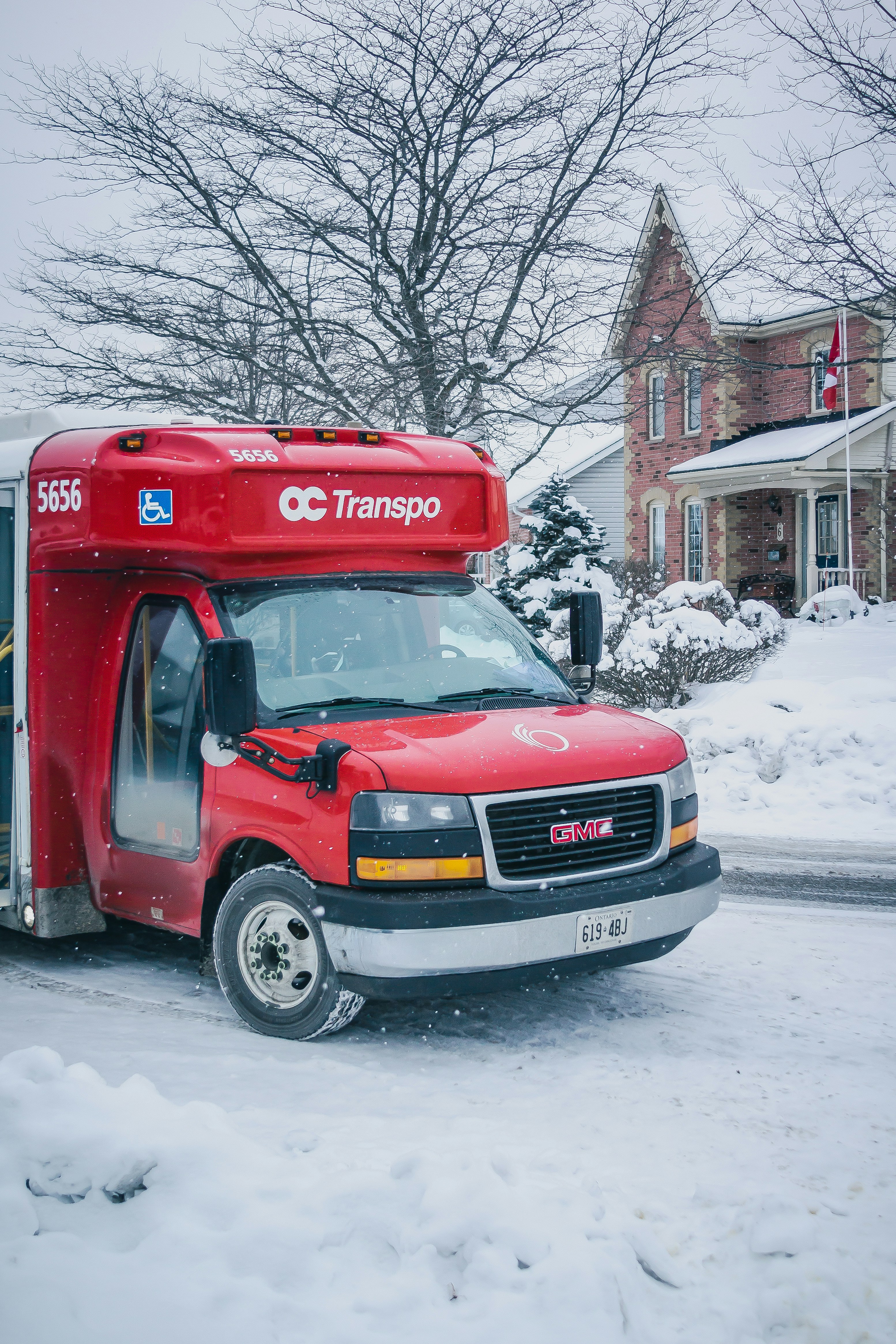 Crimson OC Transpo Bus Stands Against a Snowbound Suburban Morning