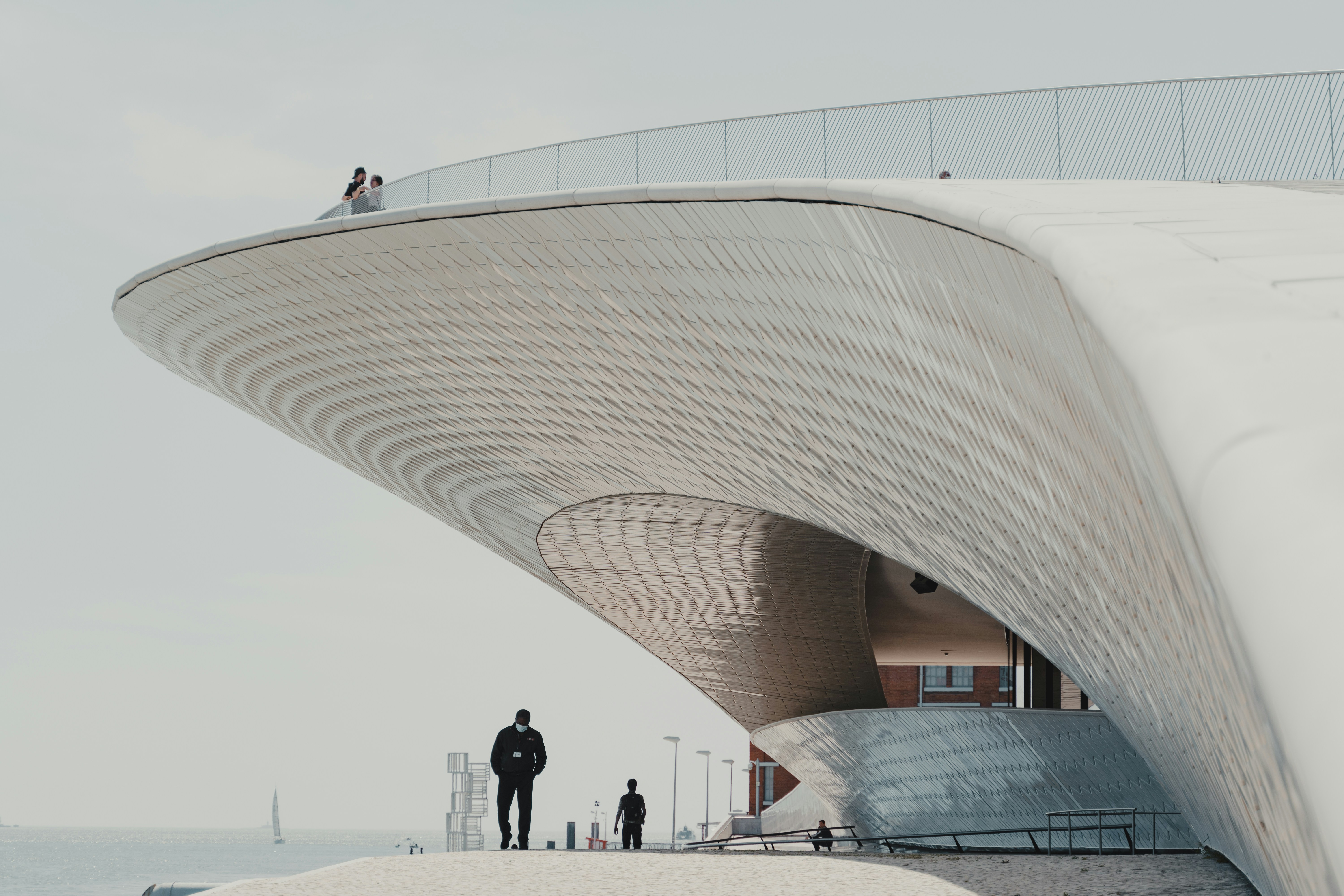 Edge of Gravity: People on a Sweeping Coastal Pavilion