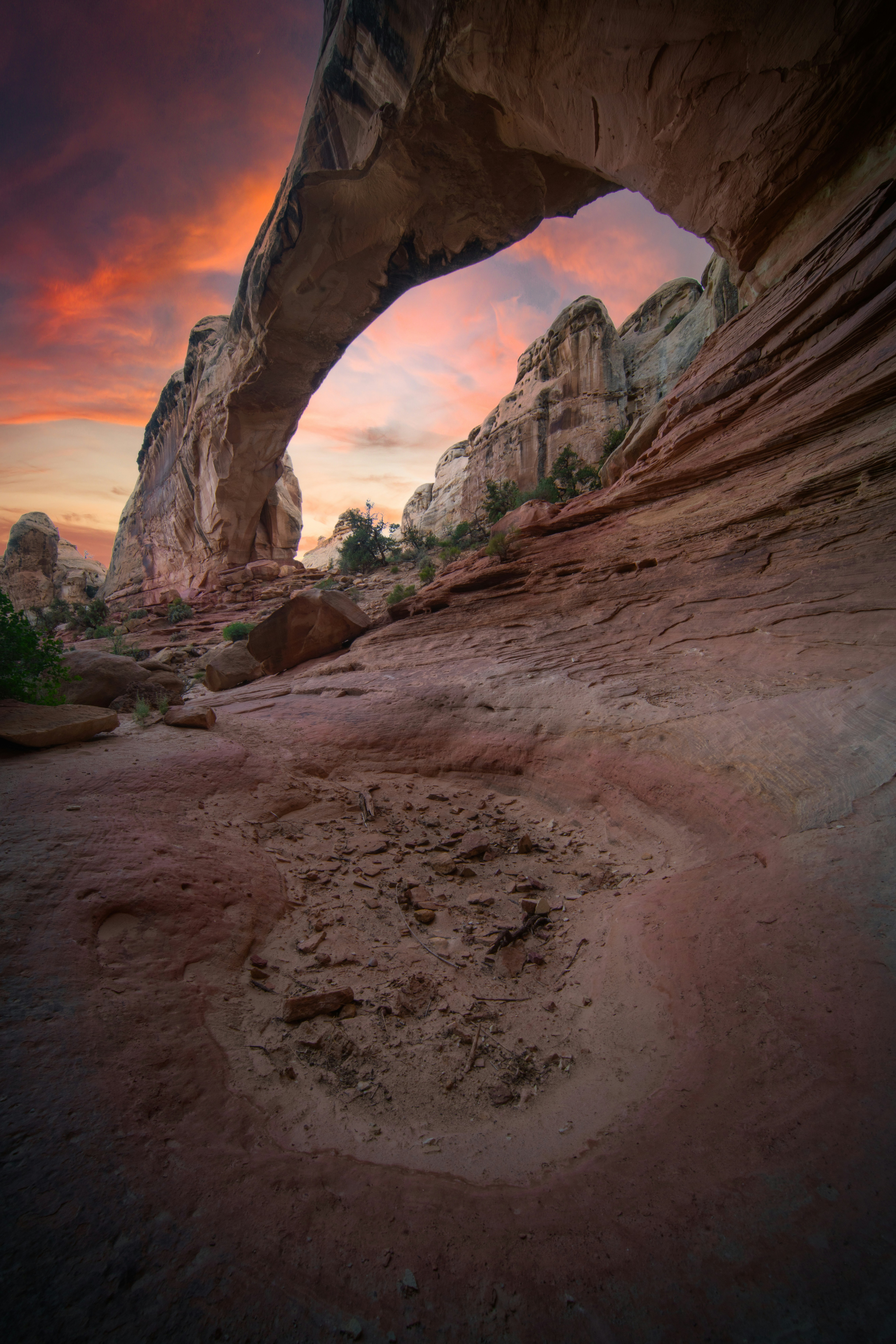 Majestic rock arch framed by vibrant sunset skies, showcasing the rugged beauty of the desert landscape.