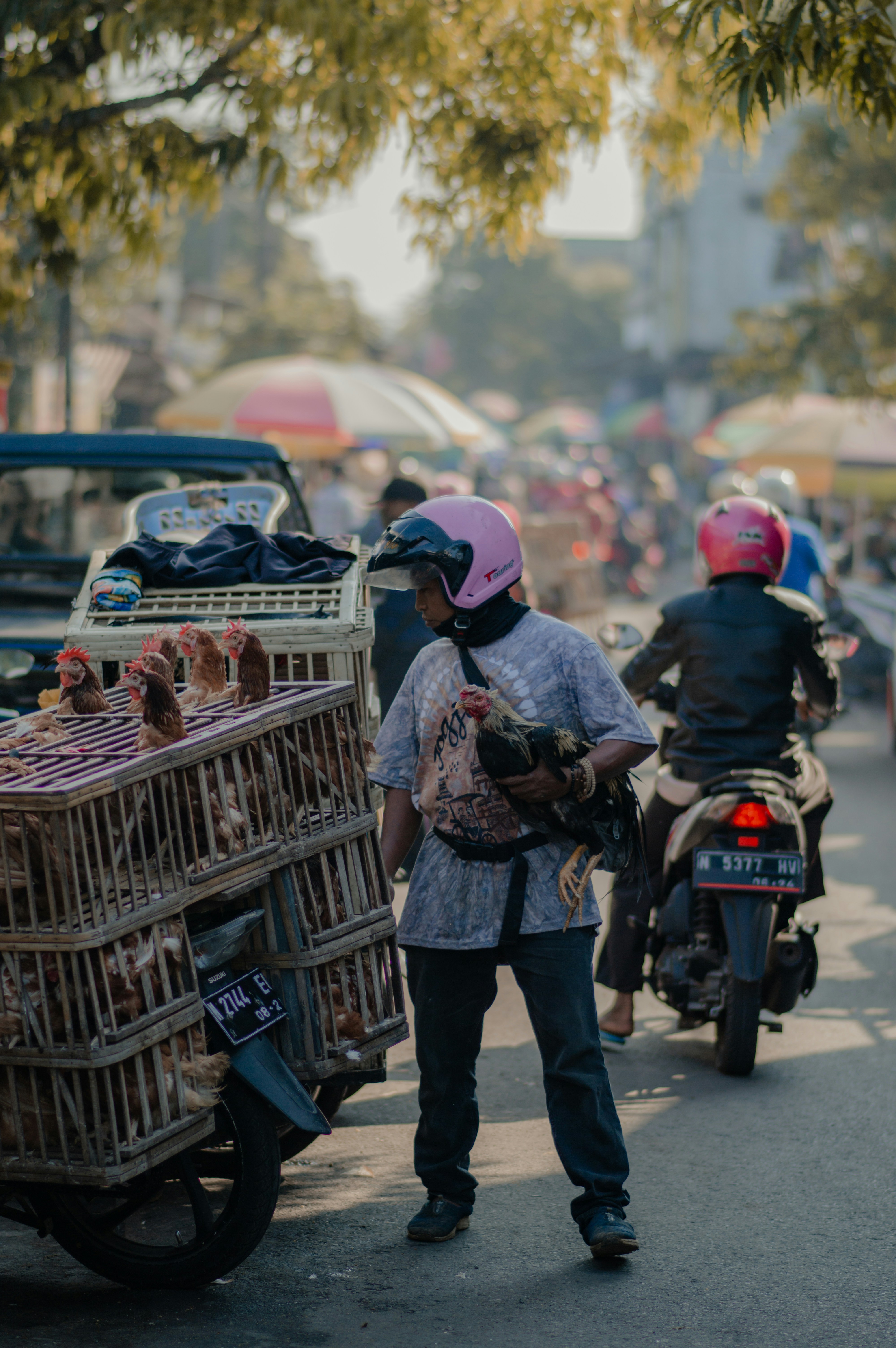 Crate Cart at the Crossroads: A Pink-Helmeted Vendor in a Bustling Market