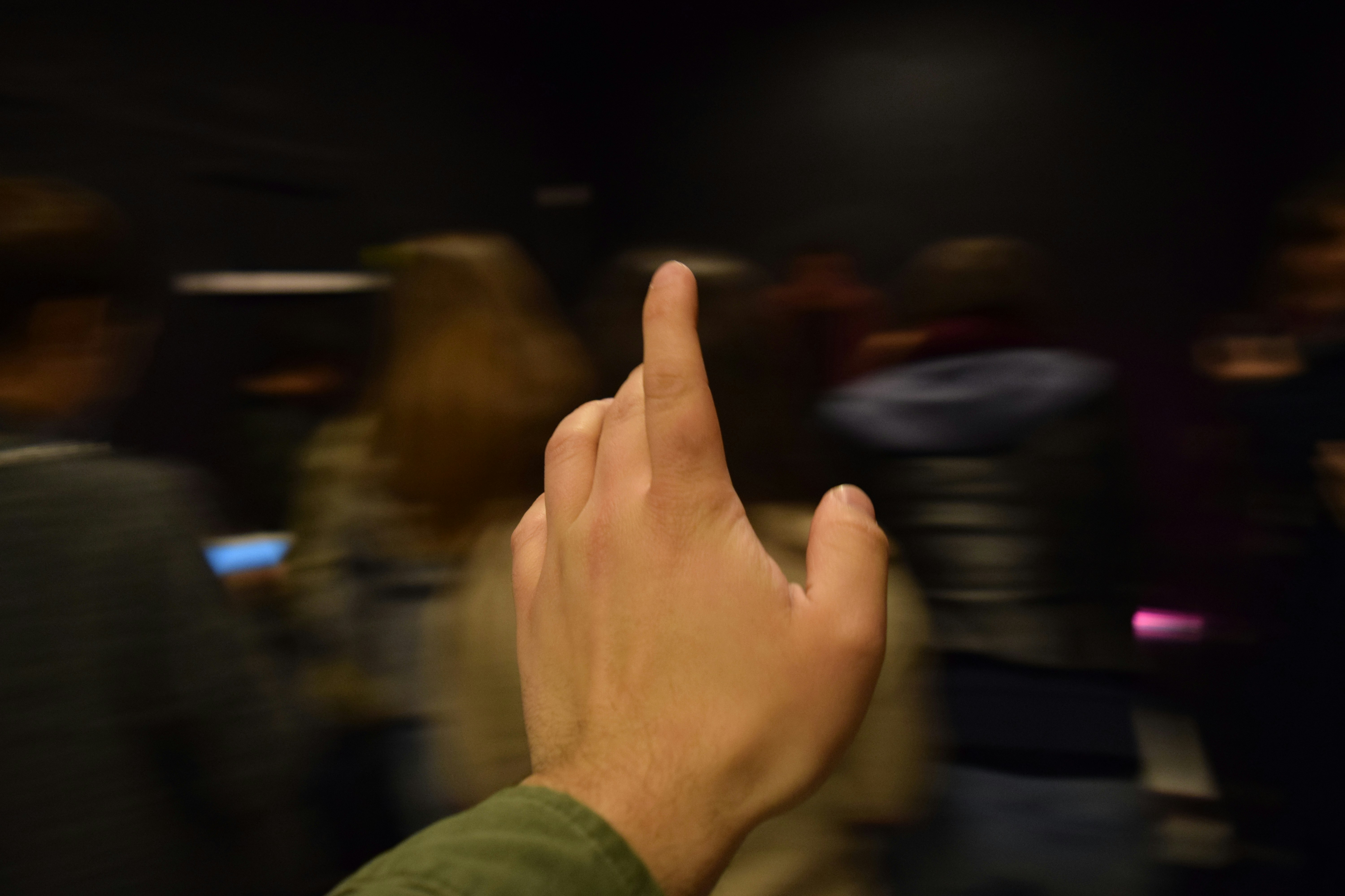 Person in green long sleeve shirt showing right middle finger photo ...