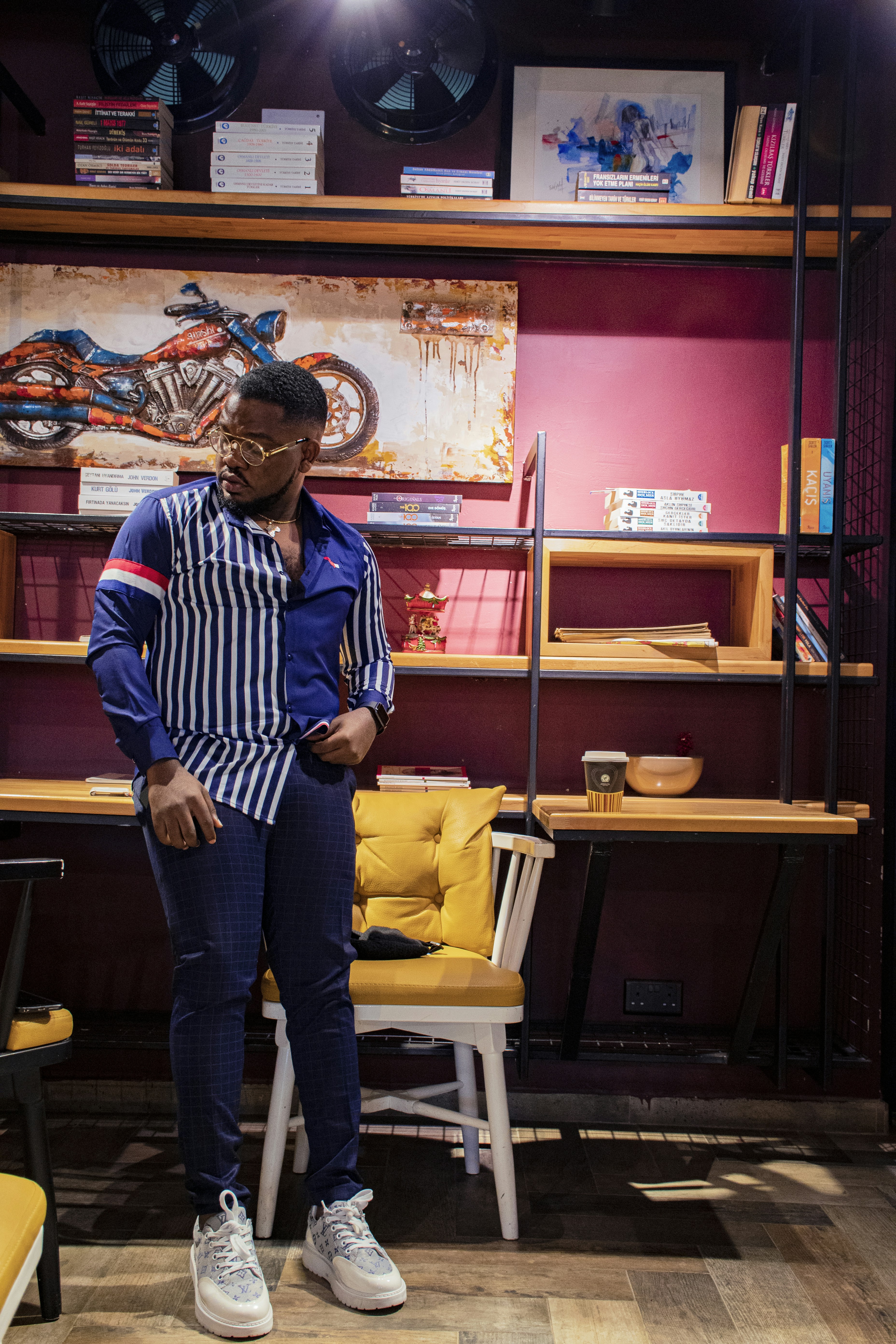 Blue Stripes in a Warm Studio: A Portrait Among Shelves