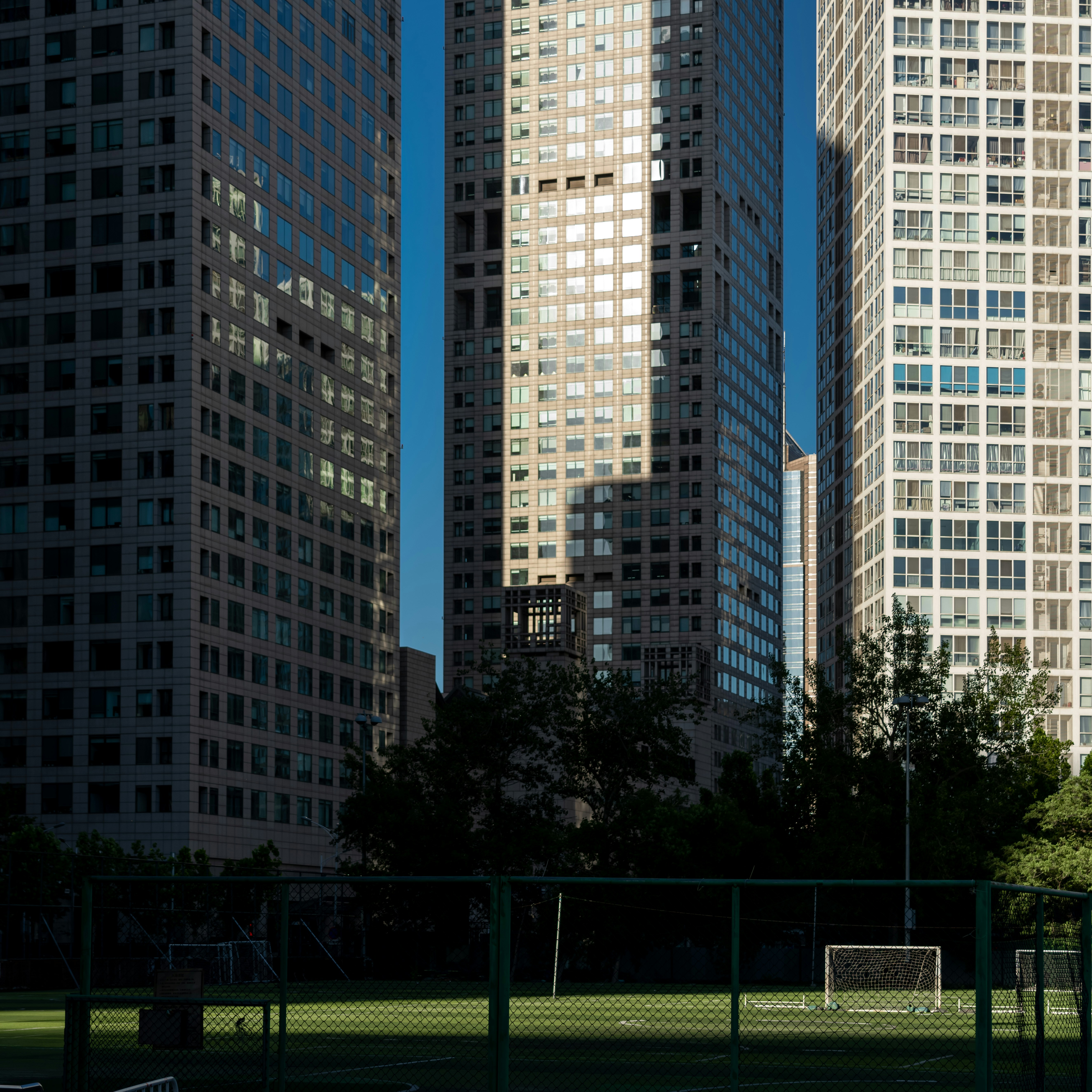 Green grass field near high rise buildings during daytime photo – Free ...
