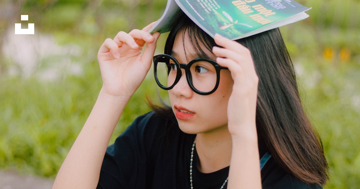 검은 크루넥 티셔츠를 입은 여자가 파란색과 흰색 책을 들고 있다 사진 Unsplash의 무료 혼자 이미지