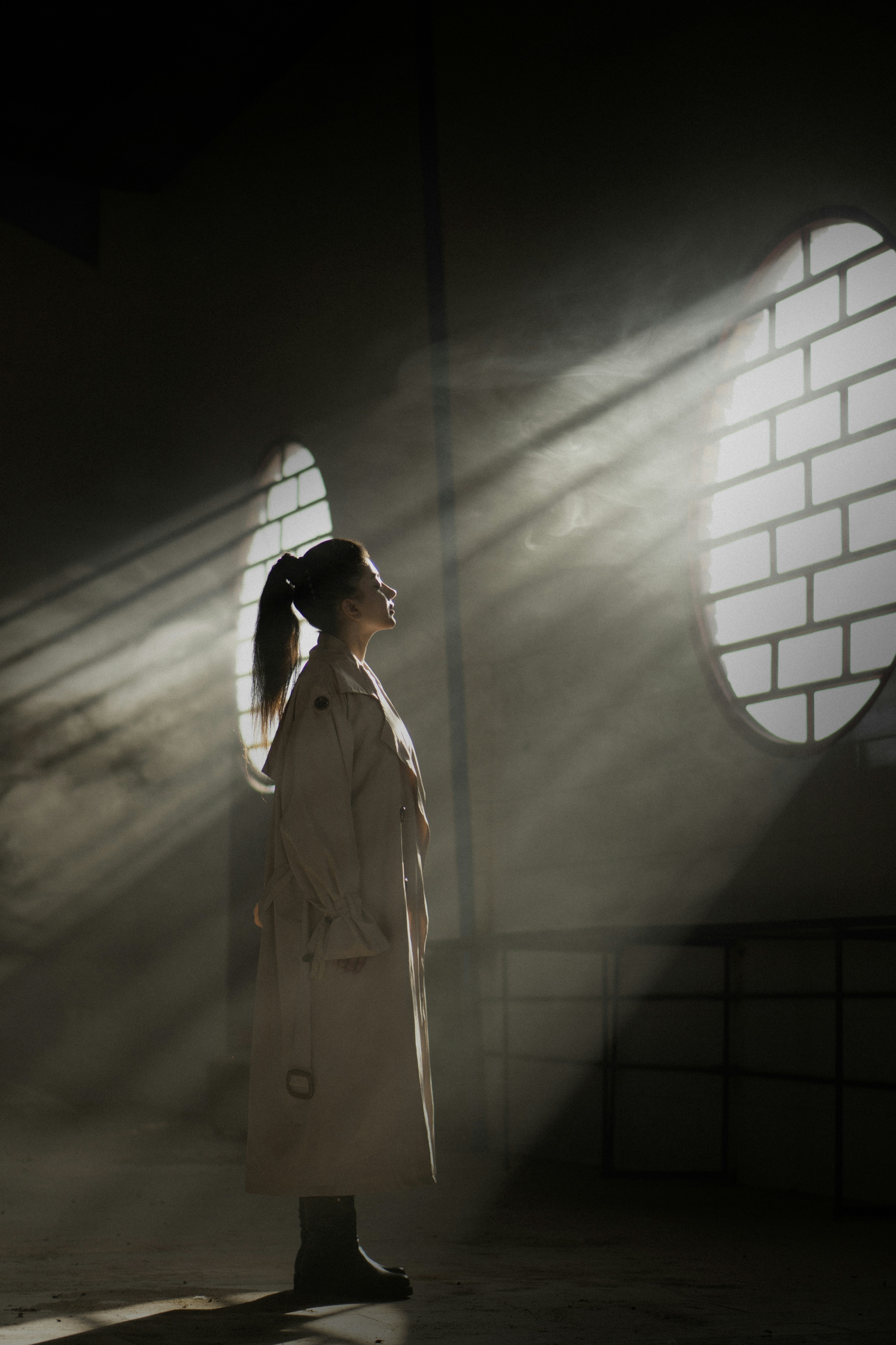 Dust and Dawn: Silhouette stepping into the light through circular windows