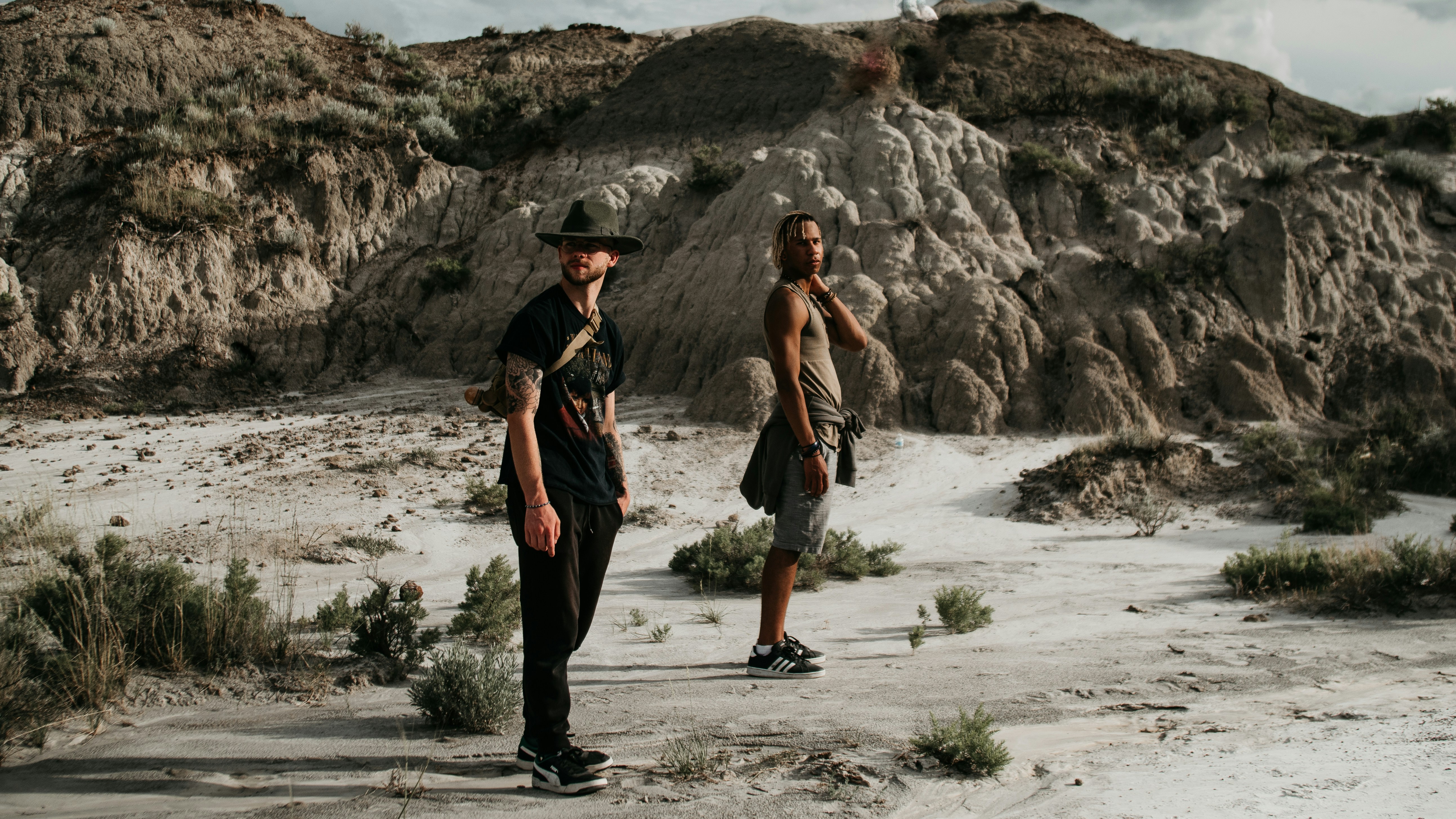 man in black tank top and black pants standing on gray sand during daytime