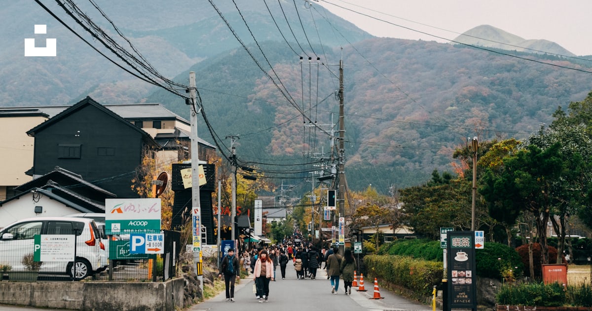 낮에 건물과 산 근처의 거리를 걷는 사람들 사진 Unsplash의 무료 일본 이미지