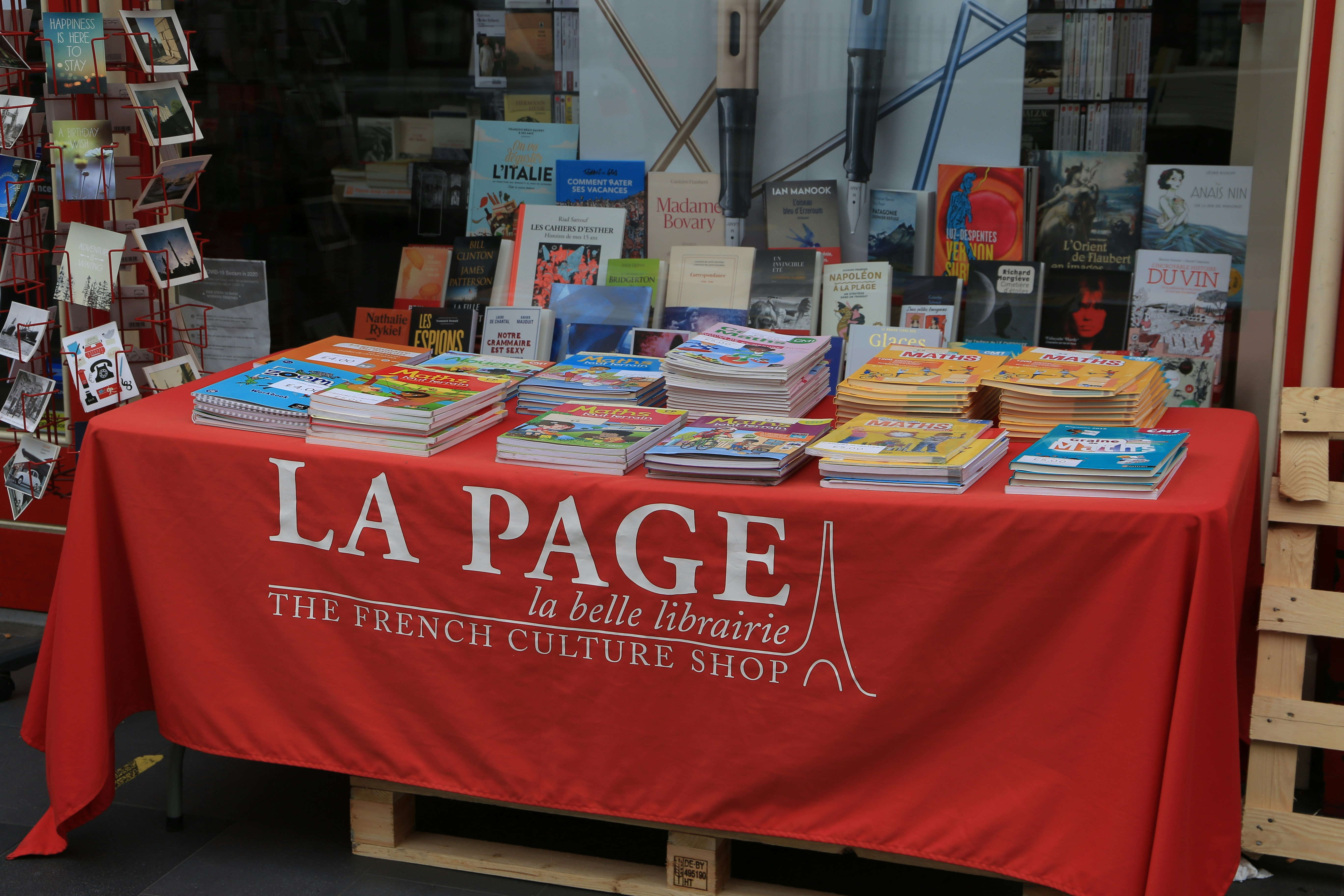 A vibrant table displaying an array of colorful books at a French culture shop, showcasing the essence of literary exploration.