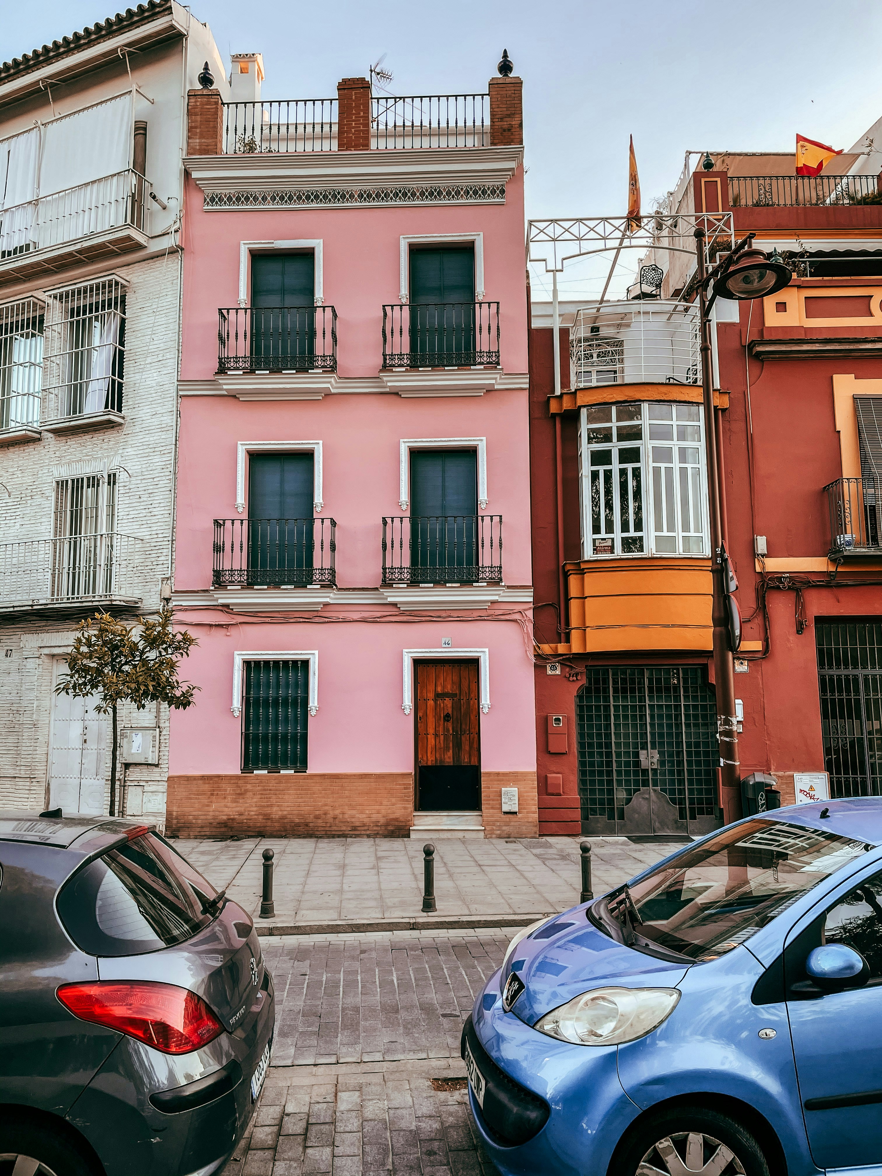 Pink Facade, Blue Cars: A Quiet Calle in Sunset Light