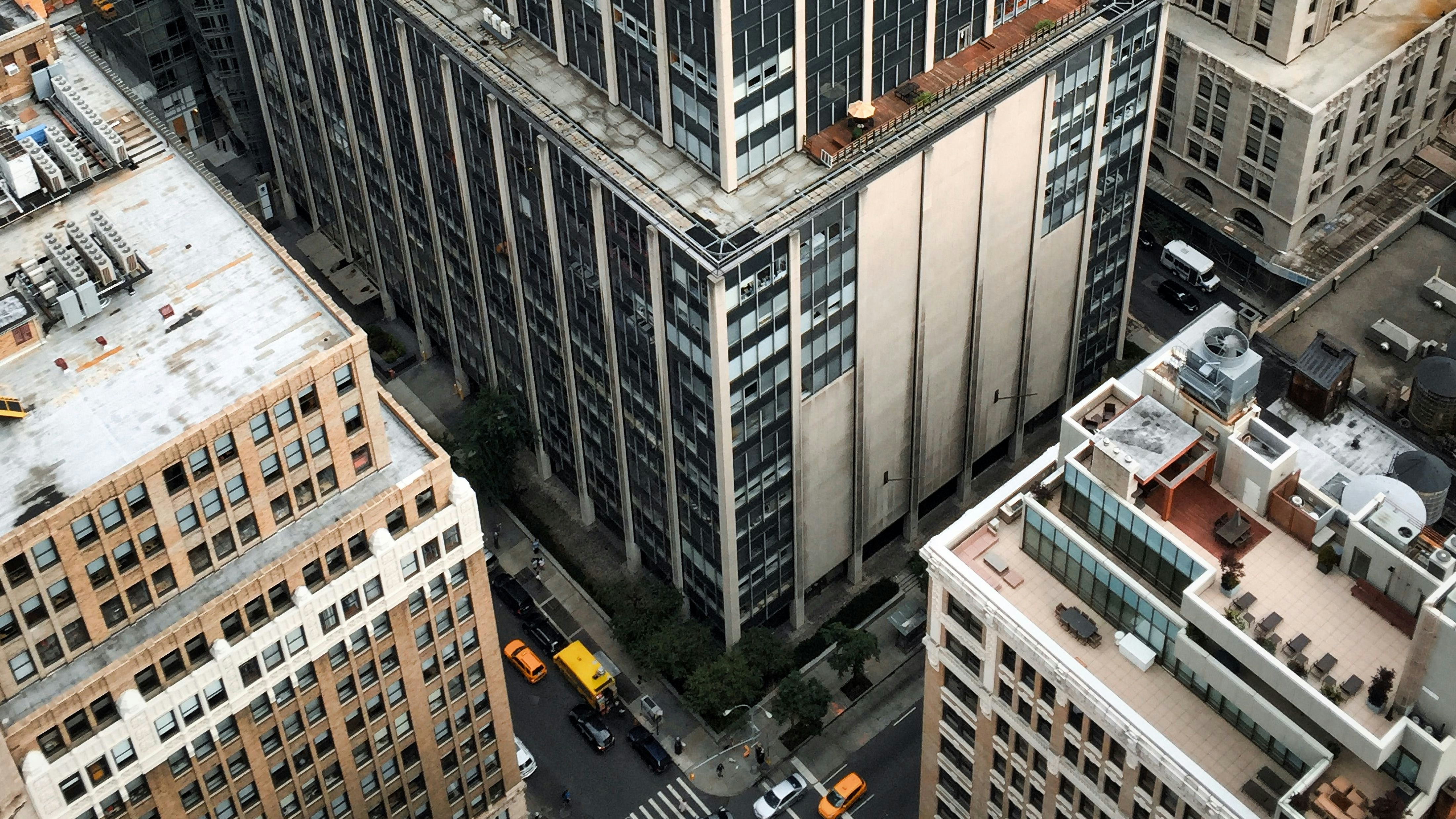 Cars parked on side of the road in between high rise buildings during ...