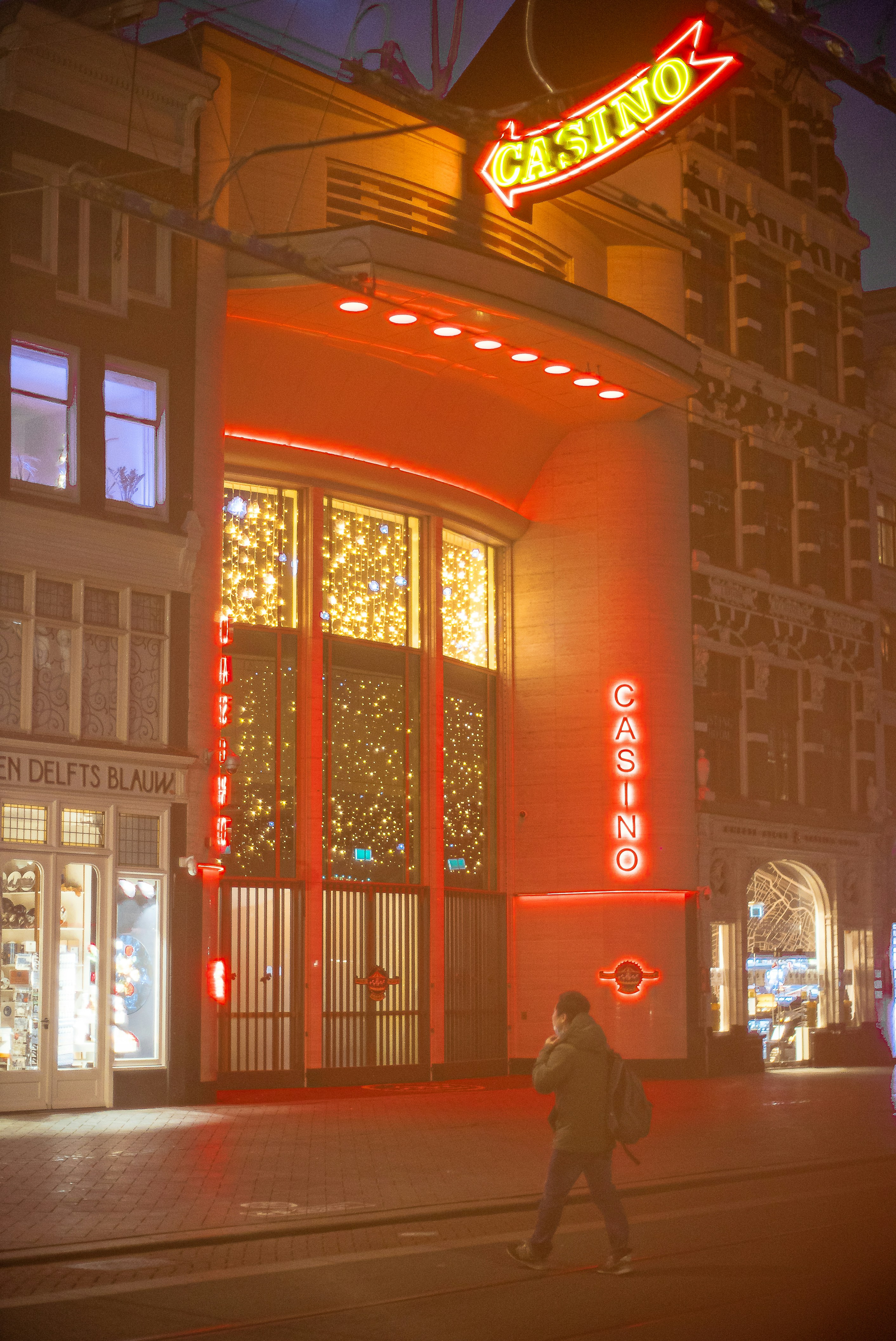 man in black jacket sitting on chair near red building