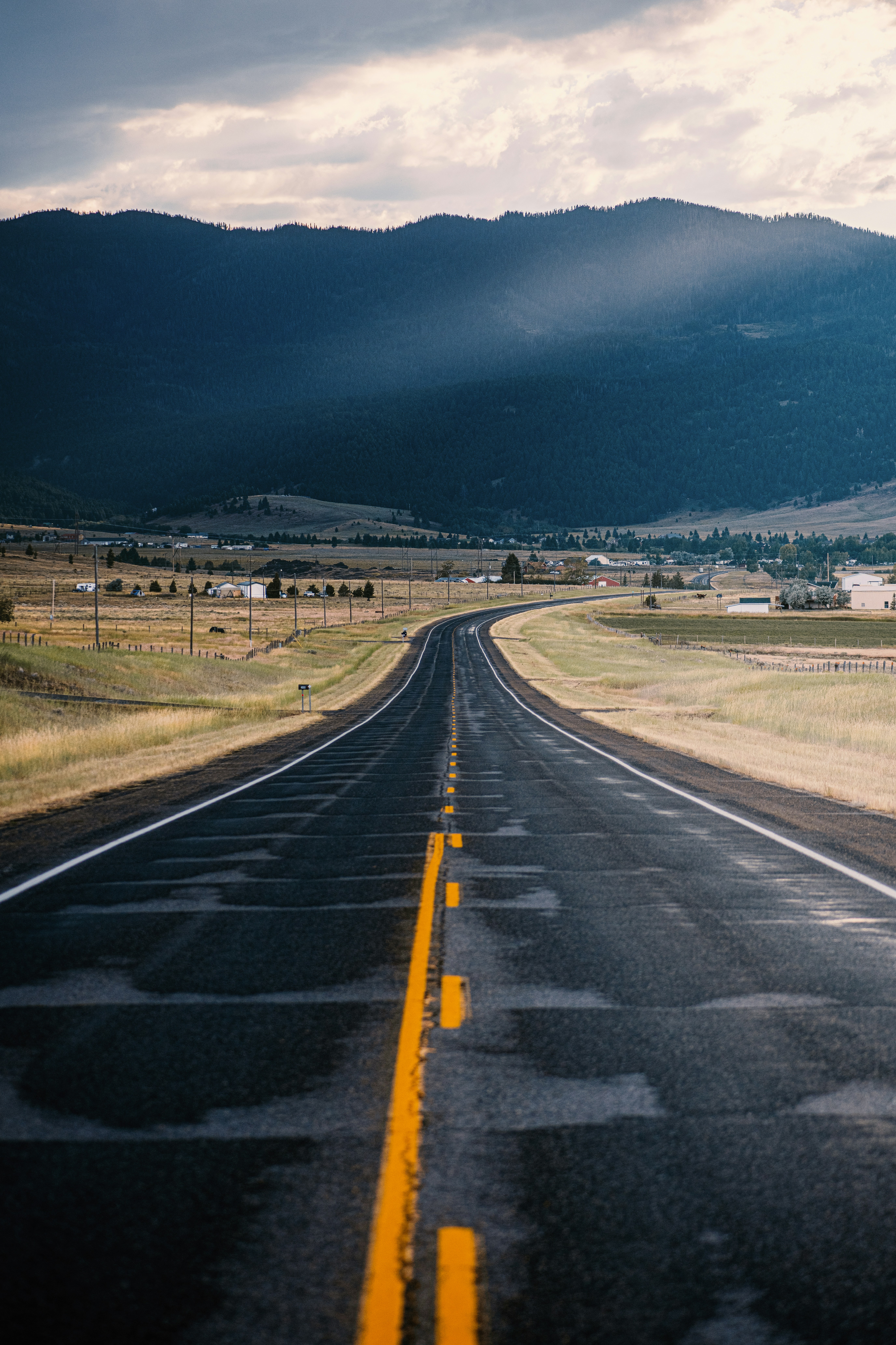 Endless Horizon: The Isolated Highway Reaching Toward Mountain Mists