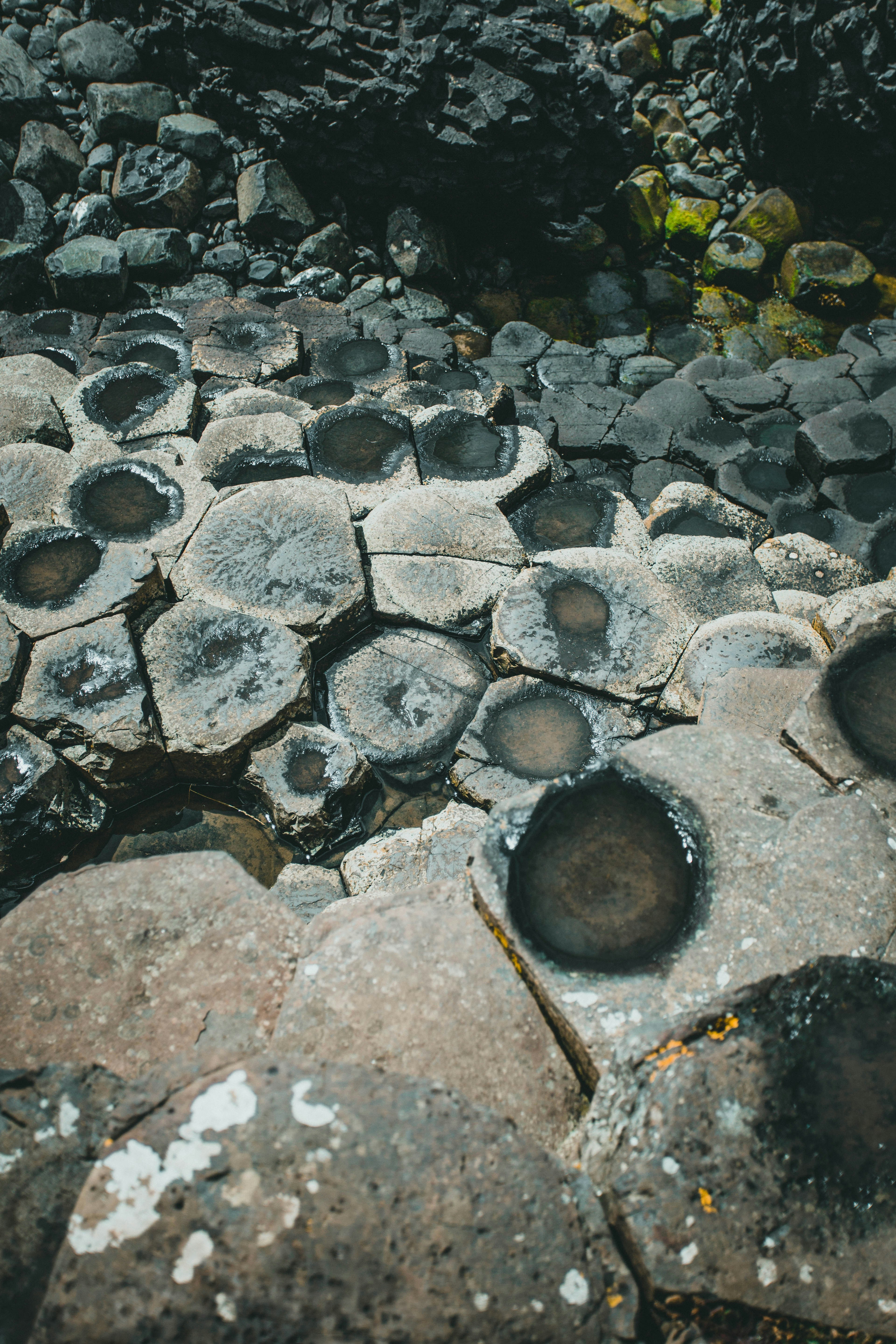 Unique hexagonal rock formations with shallow water pools, showcasing the intricate patterns of nature's design.