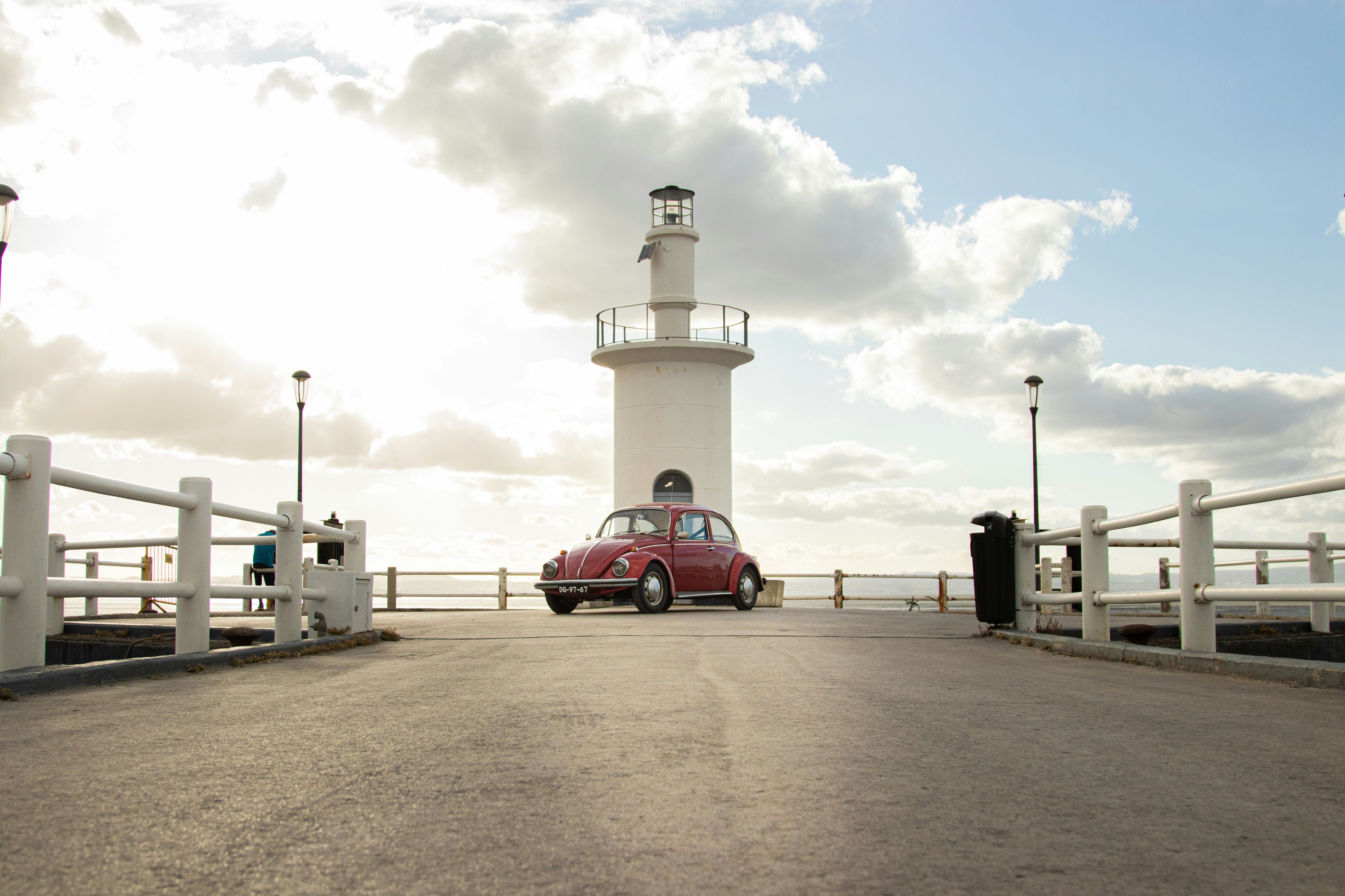 Crimson Classic at the Pier: Lighthouse Backdrop Under an Open Sky