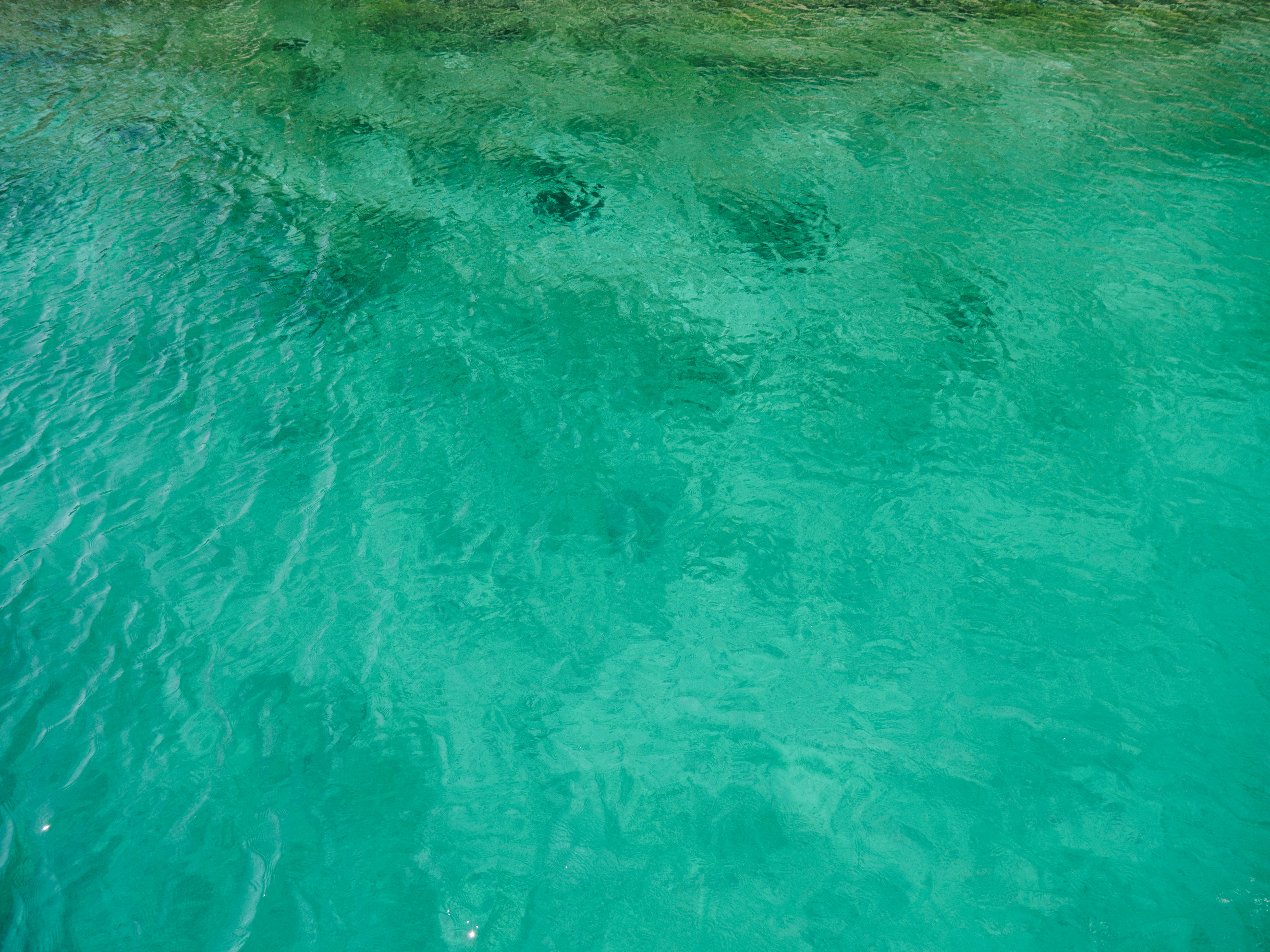 Clear aquamarine water surface reflecting light, creating a serene and calming effect.