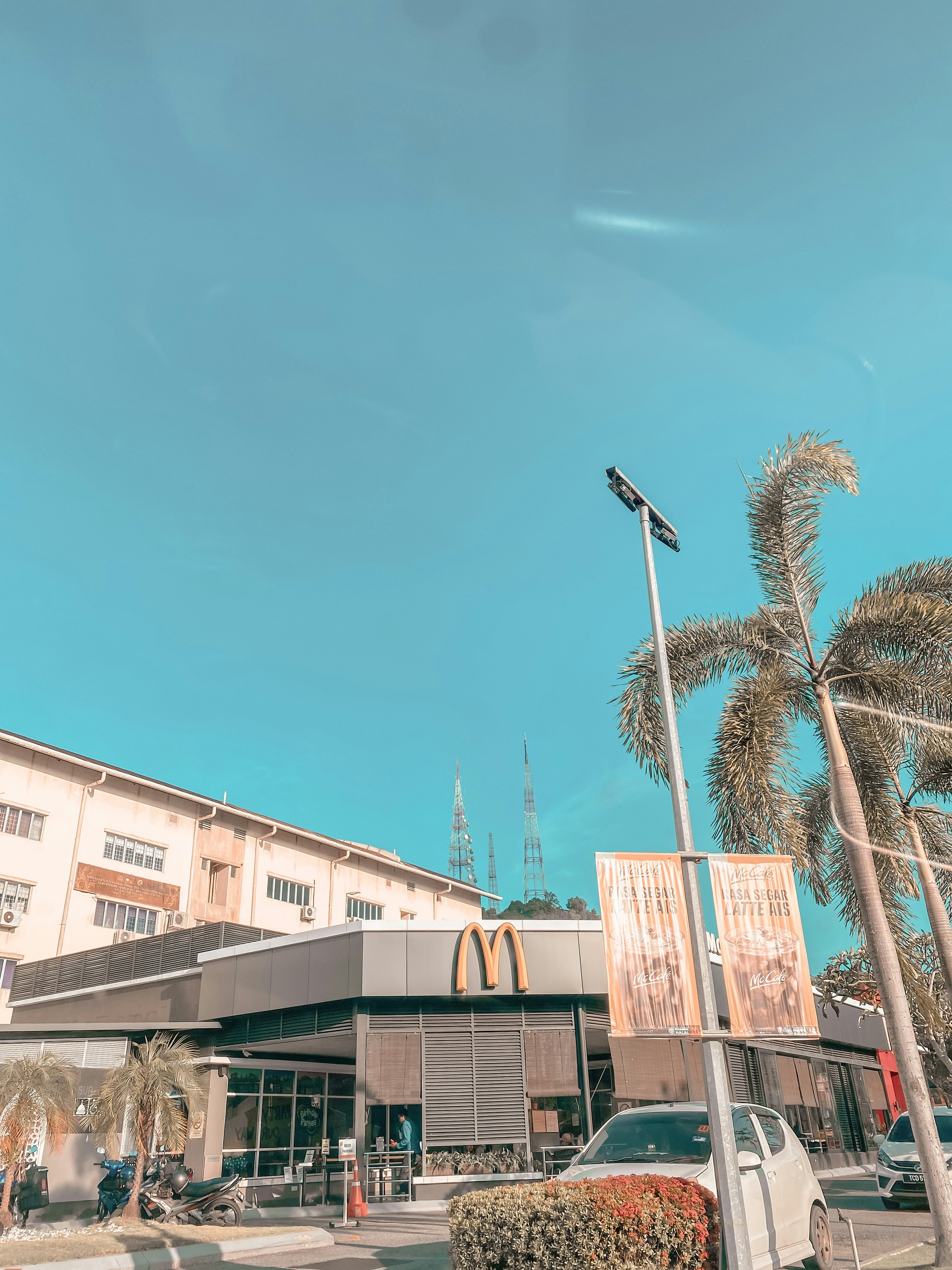 Teal Sky Over a Corner McDonald's with Palm Shadows
