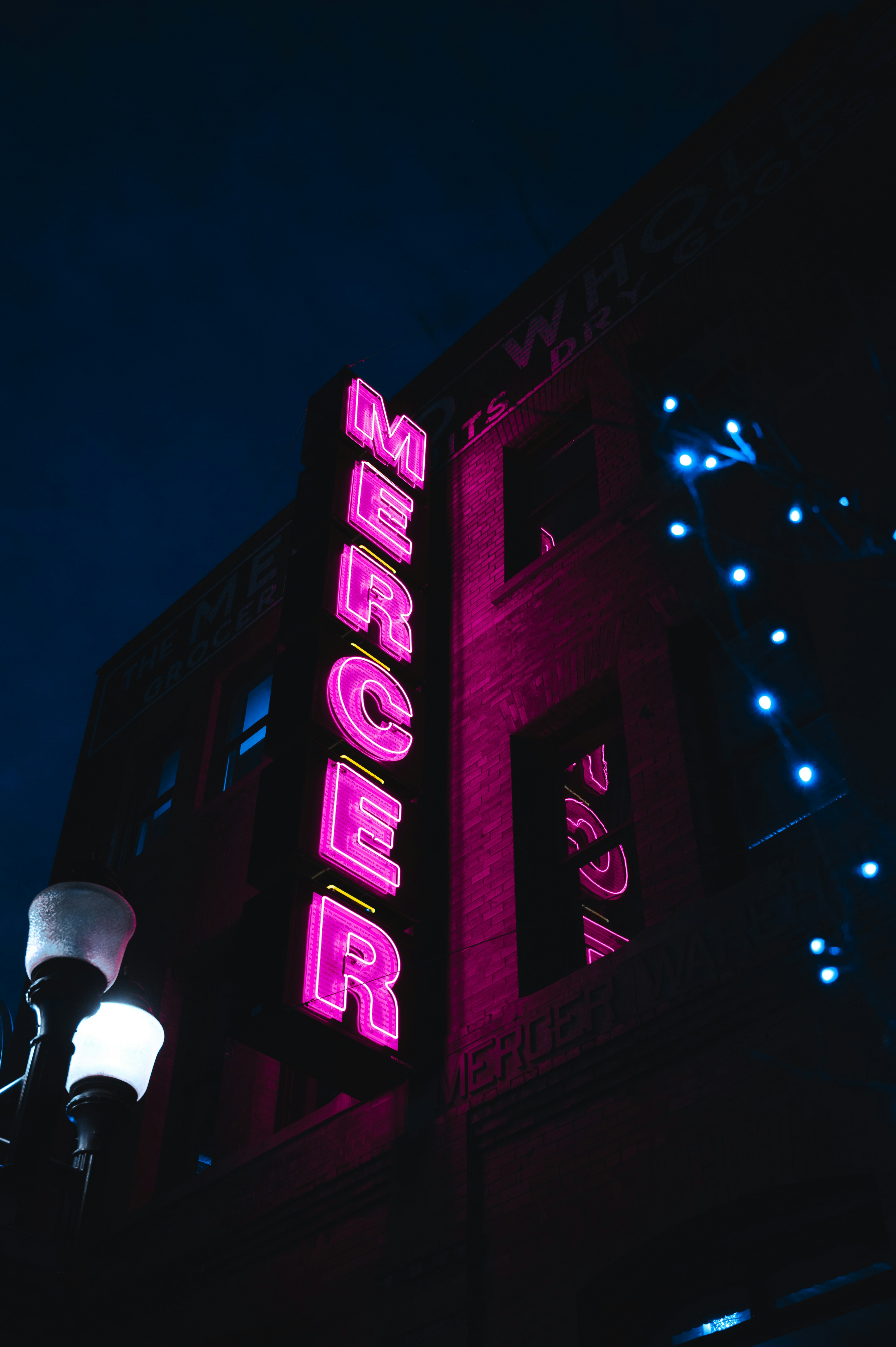 A large neon sign on the side of a building photo – Free Building Image ...