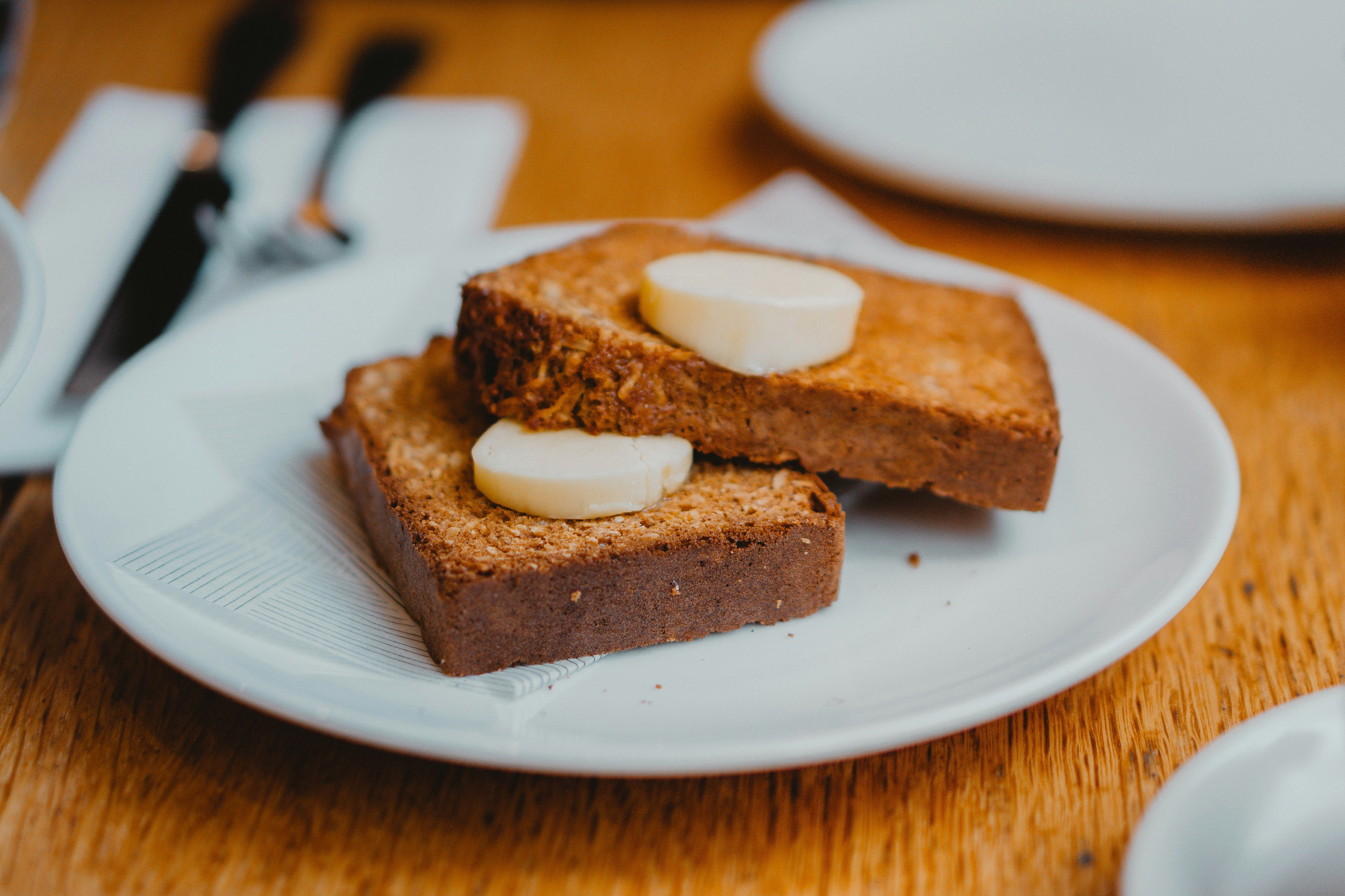 Foto Pan rebanado en plato de cerámica blanca – Imagen Pan de molde ...