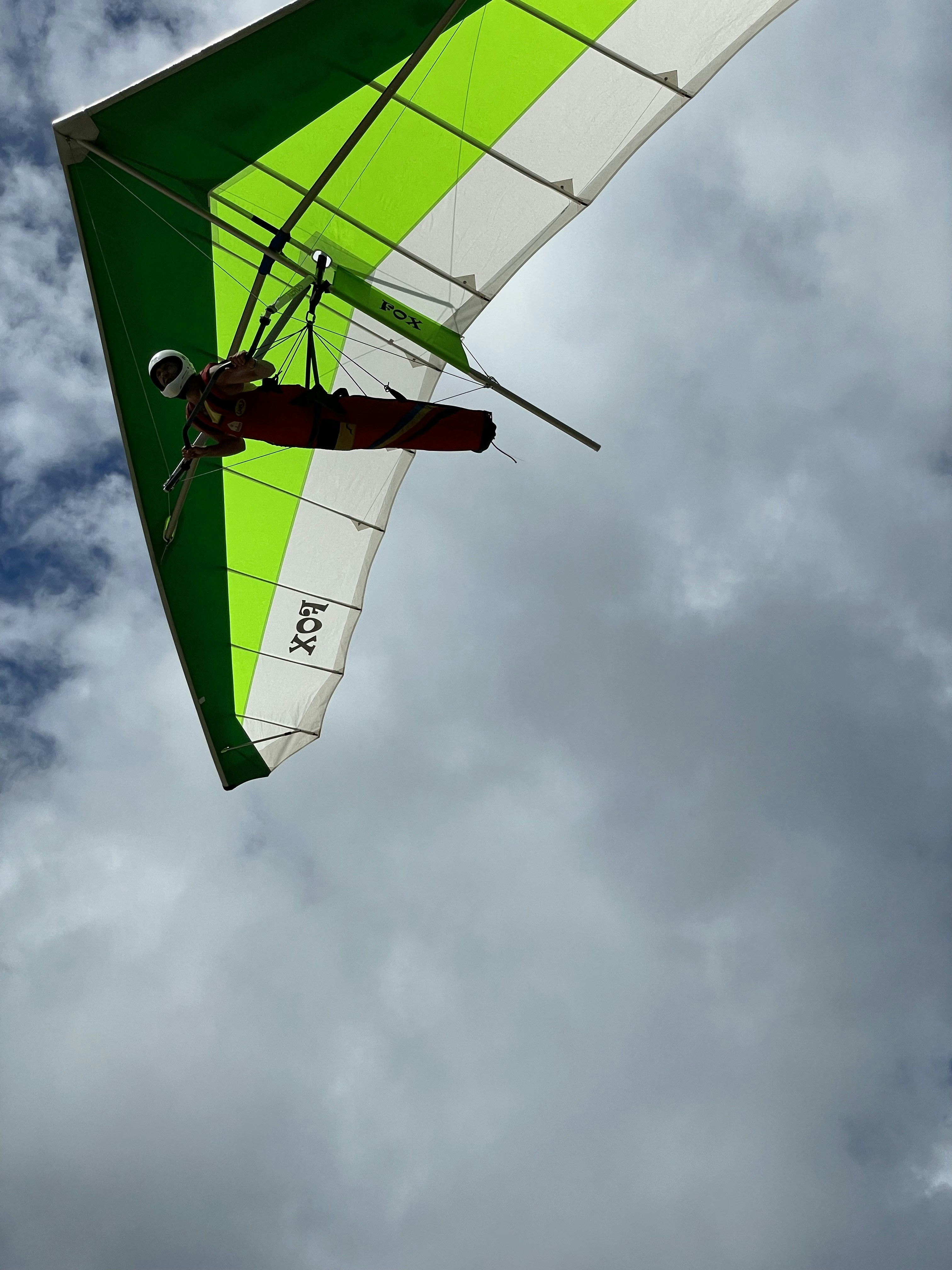 Neon Wing in a Looming Sky: A Hang Glider's Bold Leap