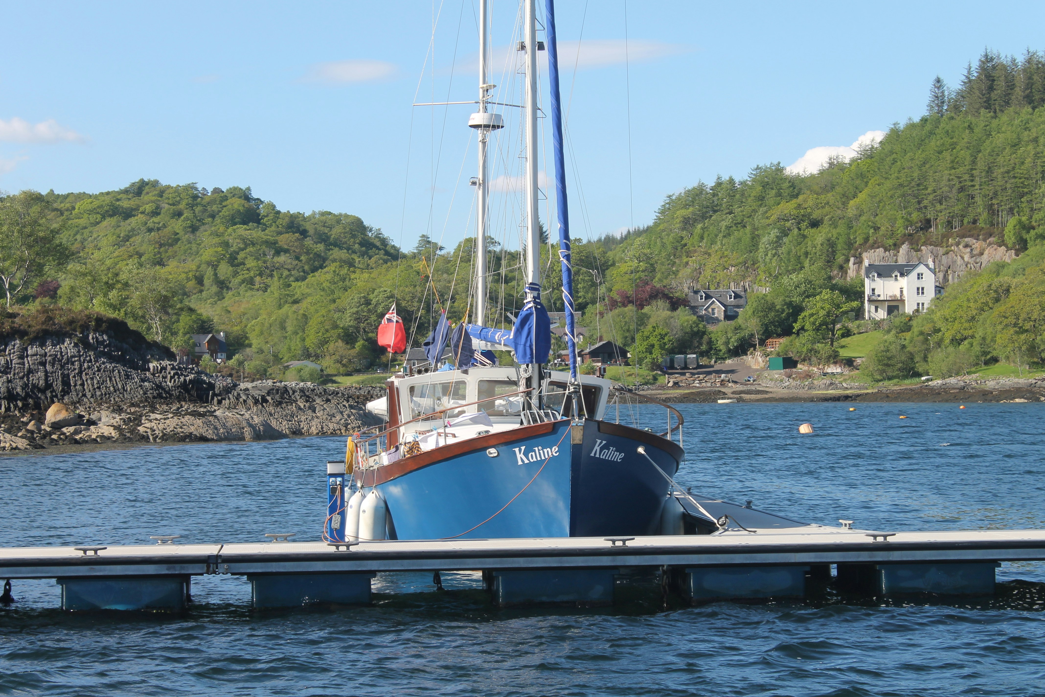 Blue Sloop at Quiet Harbor Dock