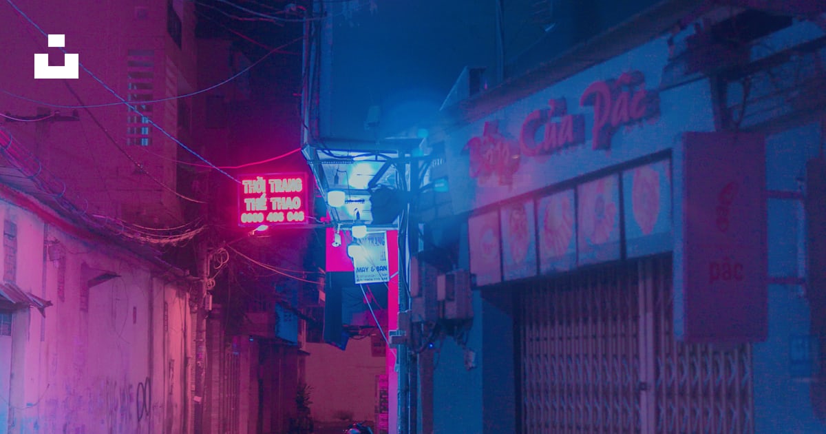 검은 재킷을 입은 남자가 밤에 거리를 걷고 있다 사진 Unsplash의 무료 건물 이미지