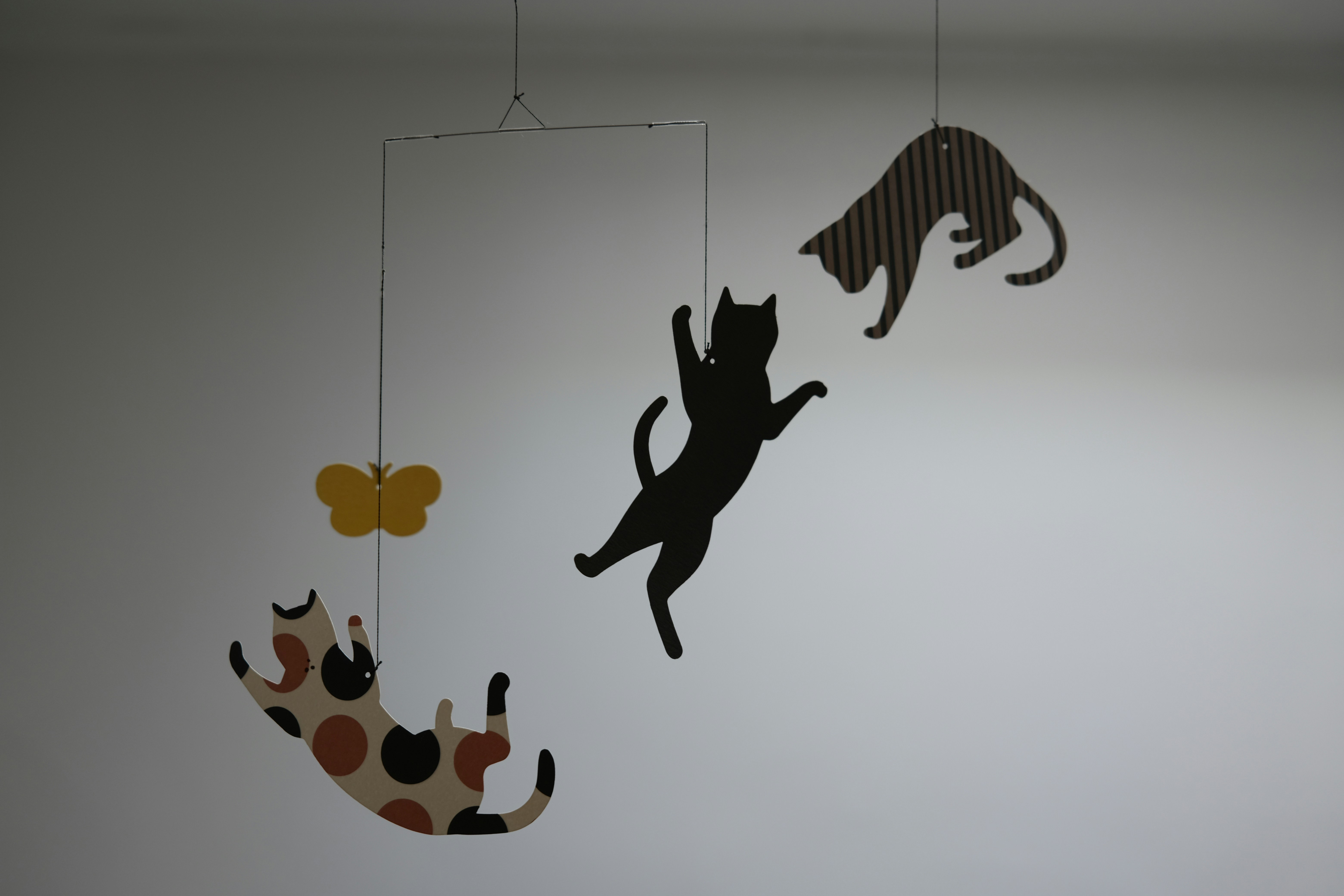 Midair Silhouettes: A Leaping Cat Among Hanging Cutouts
