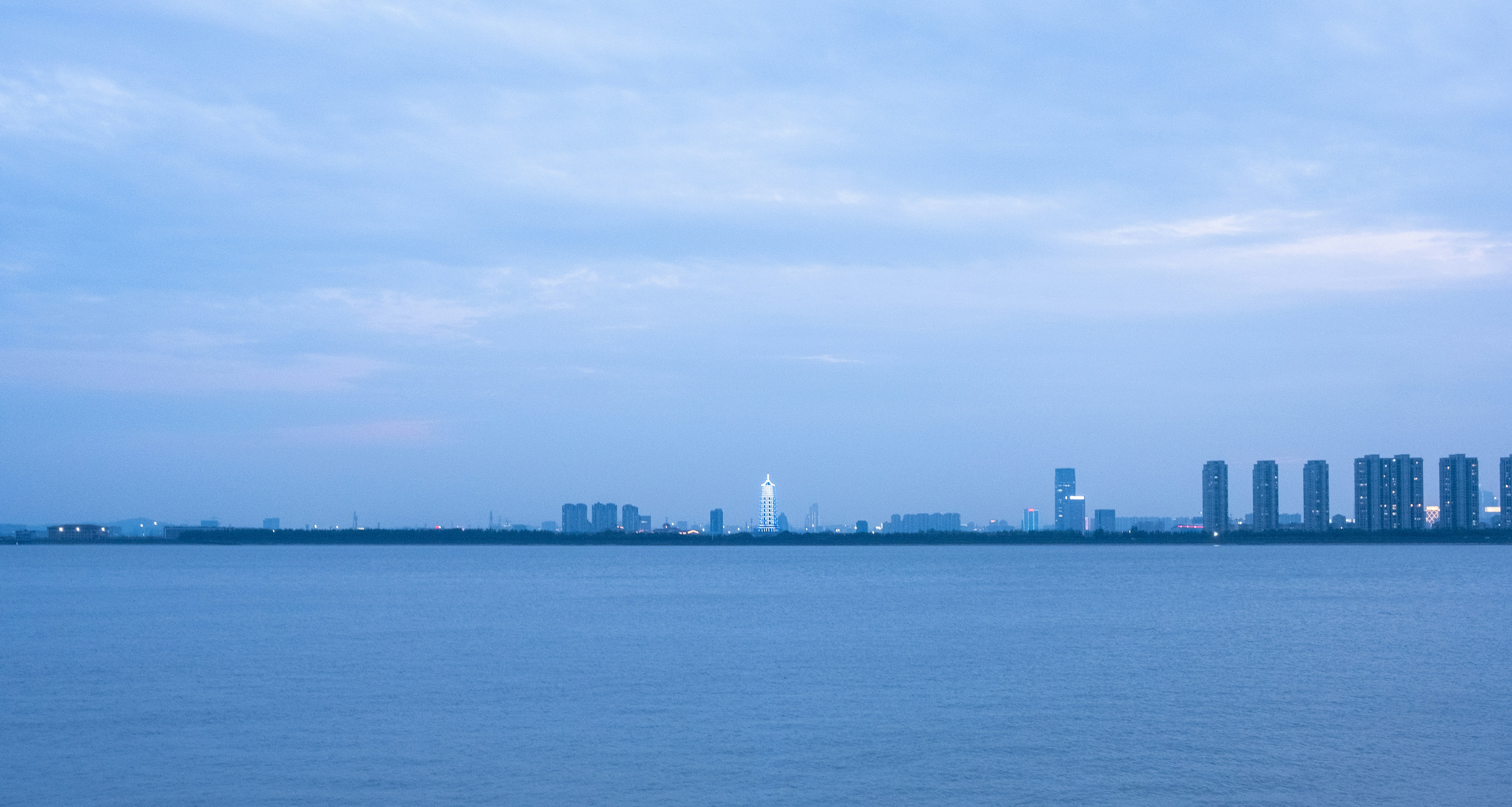 Coastal Skyline at Dusk: Horizon Lines meet a Quiet Blue Sea