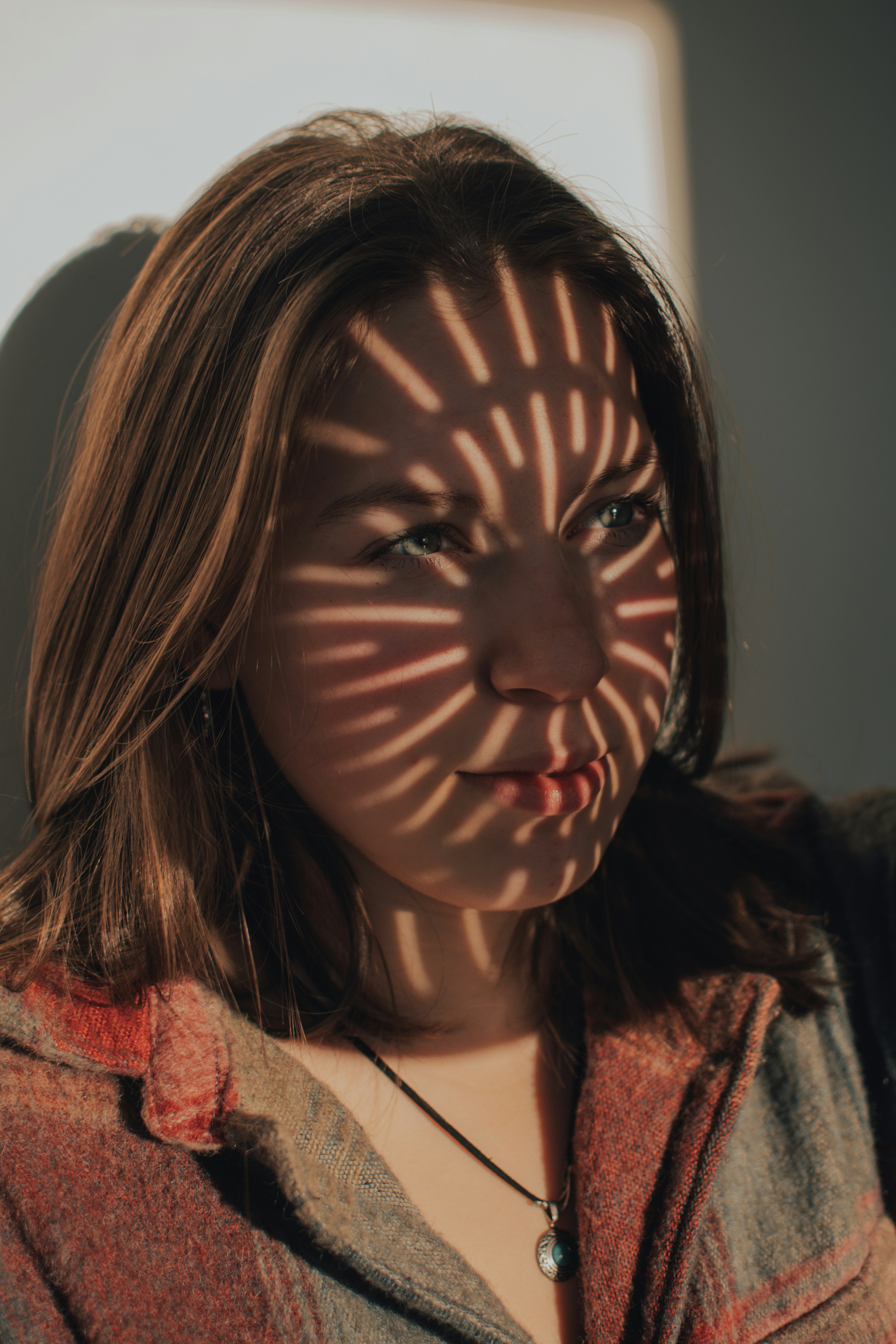 Sunburst Gaze: Portrait Framed by Striped Window Light