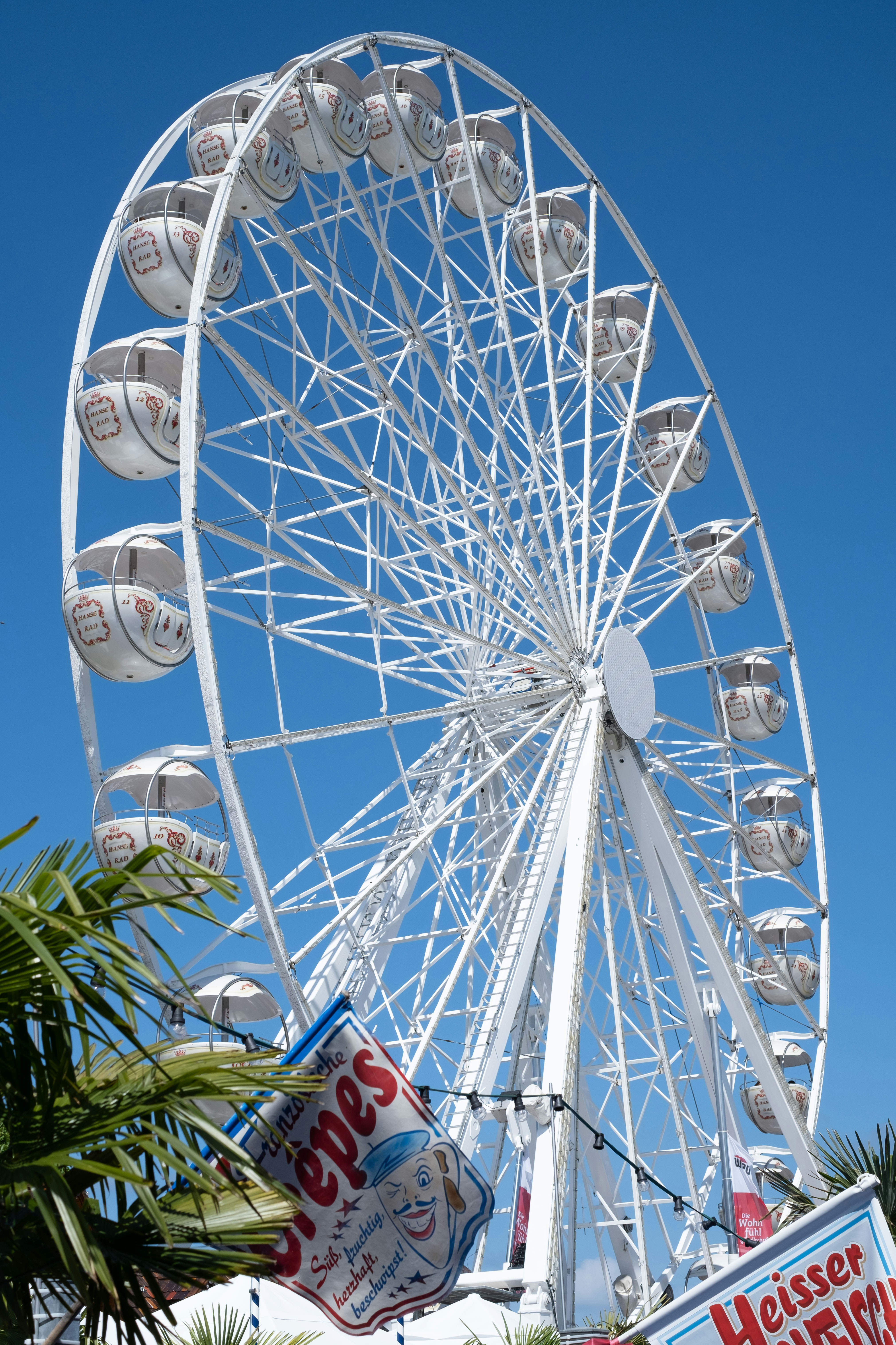 Azure Sky, White Spokes: A Ferris Wheel Reaches for the Sun