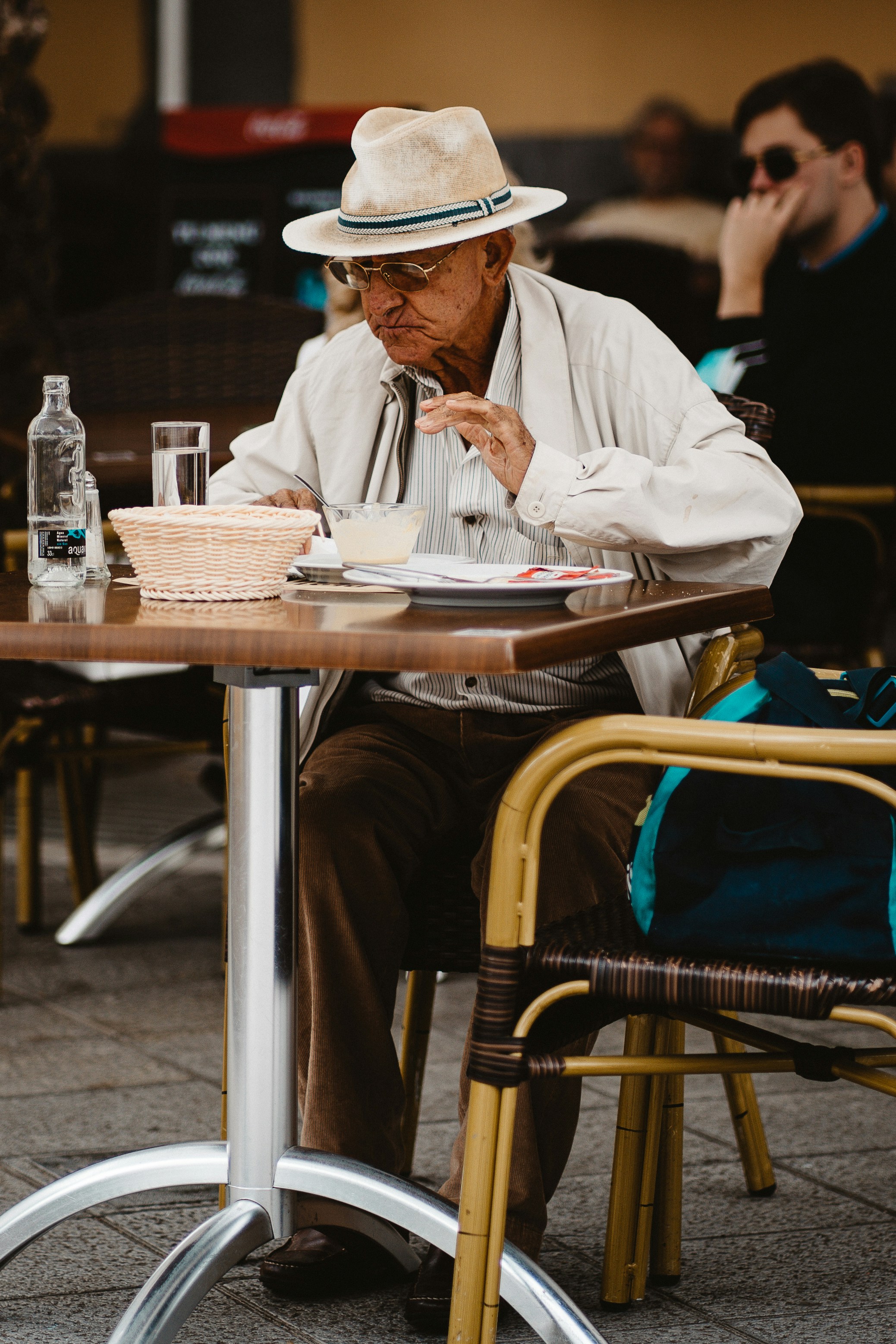 White-Hatted Quietude at a Sunlit Café Table