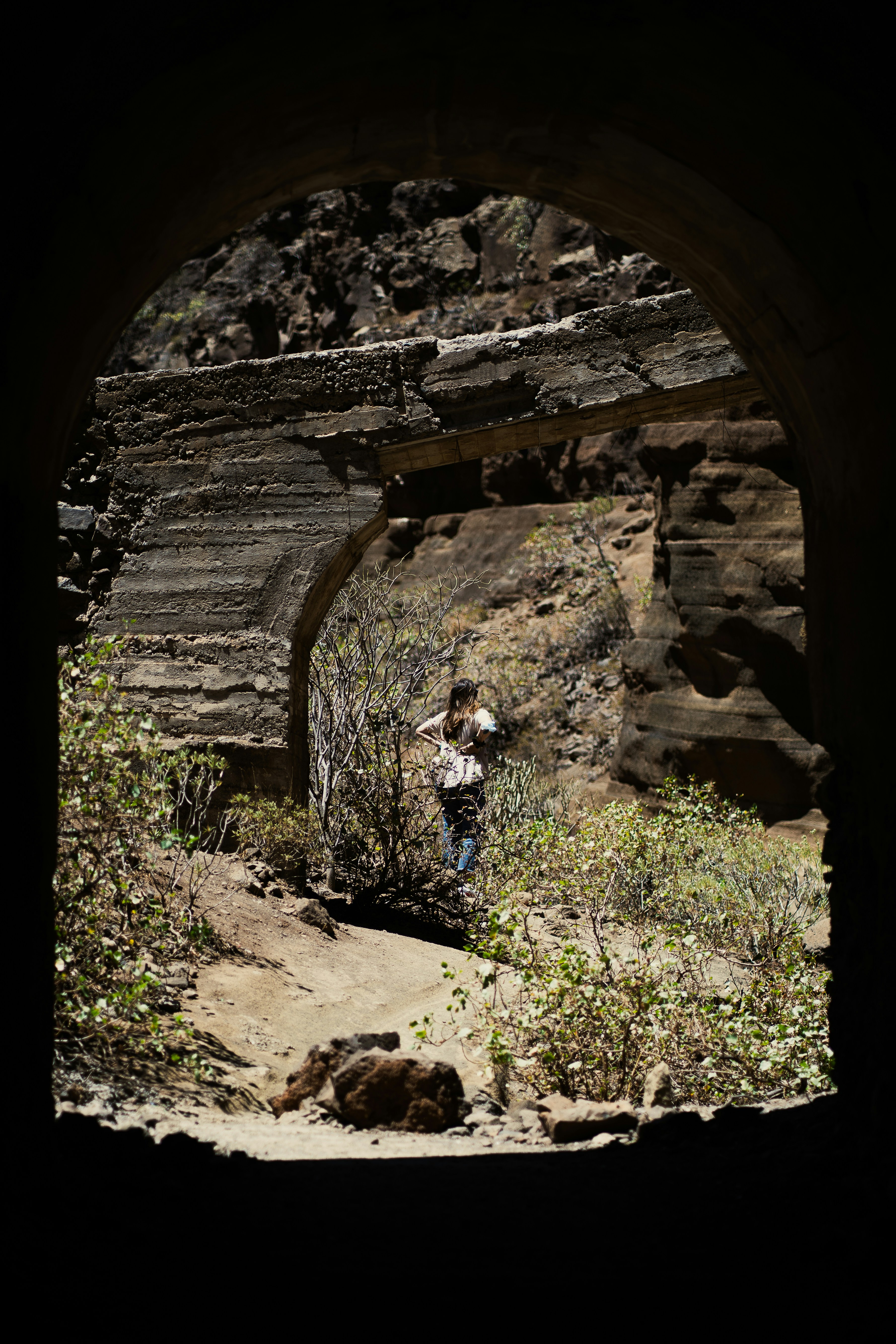 Sunlit Wanderer Framed by a Desolate Stone Arch