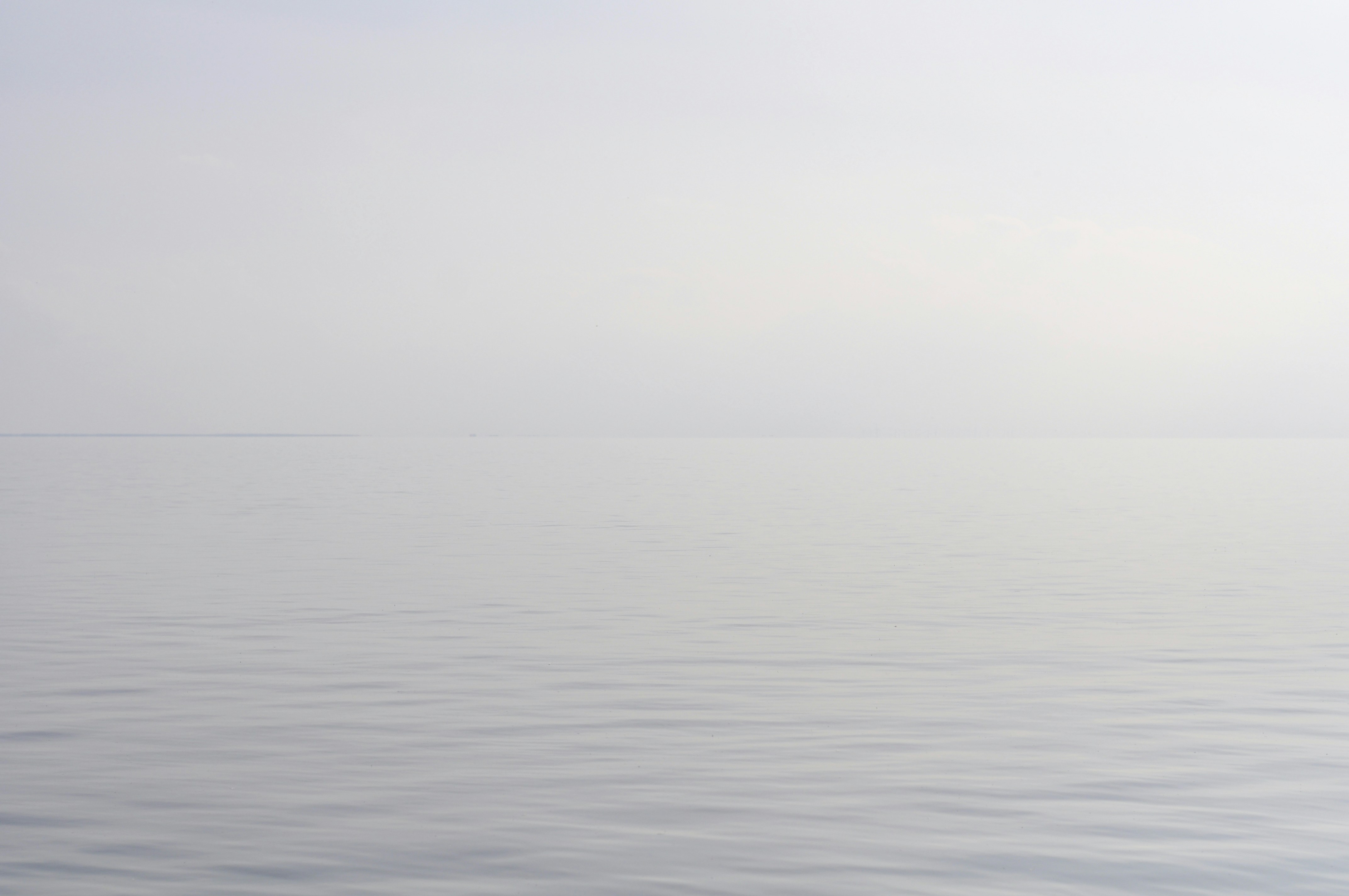 Softly rippling water meets an ethereal sky, creating a harmonious blend of calmness and simplicity.