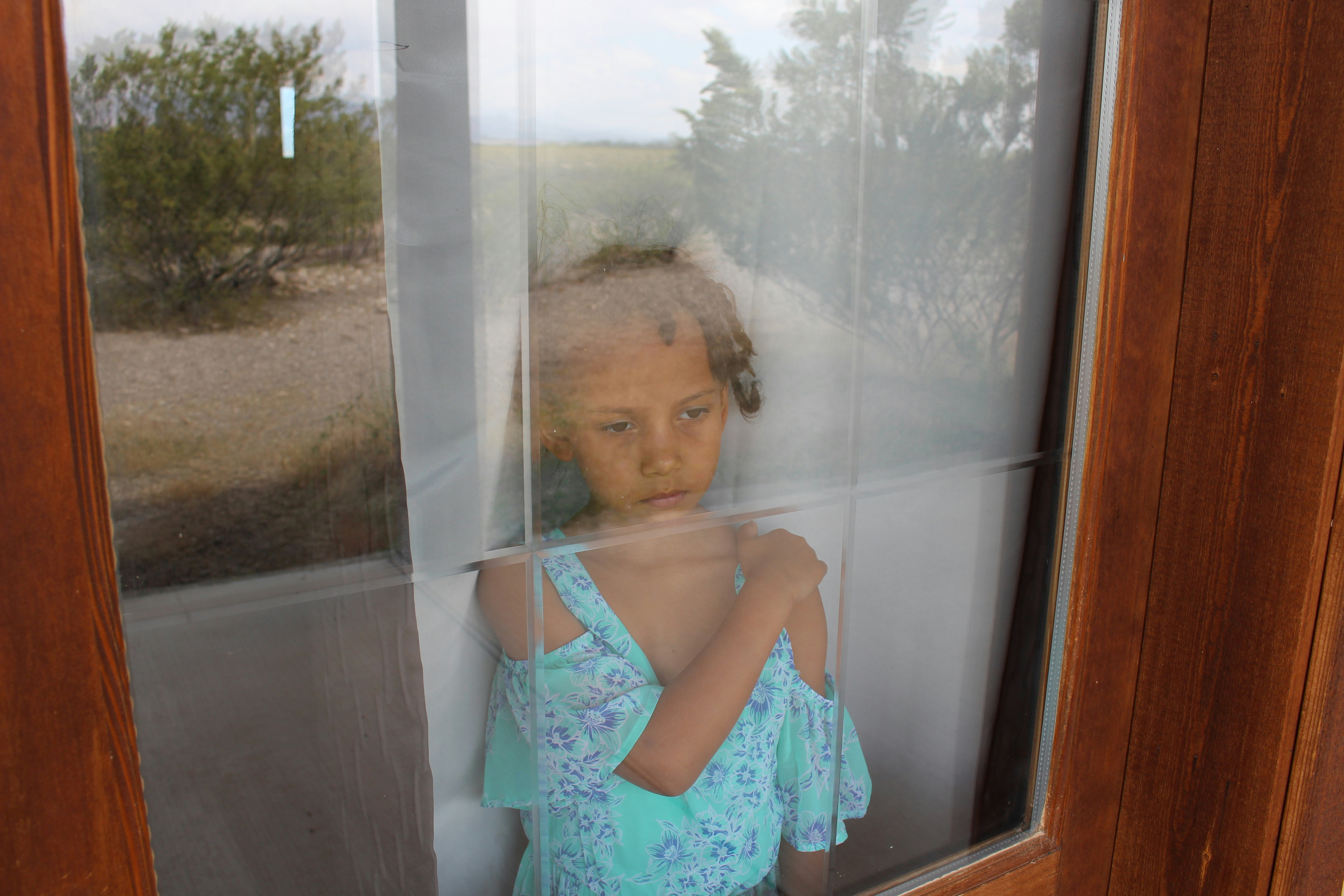 Through the Glass: A Quiet Portrait of a Girl Behind Reflections