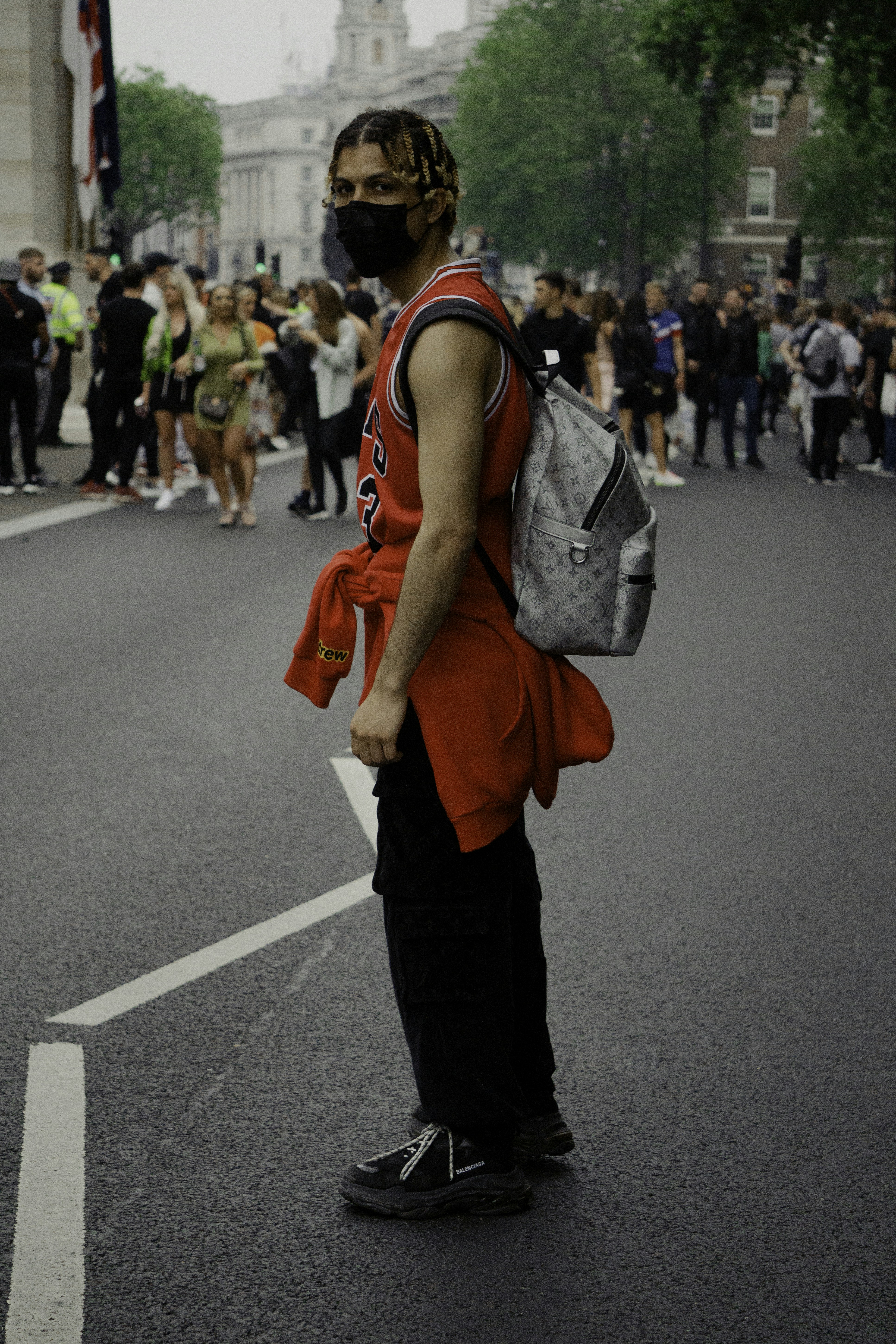 woman in red and black jacket and black pants walking on road during daytime