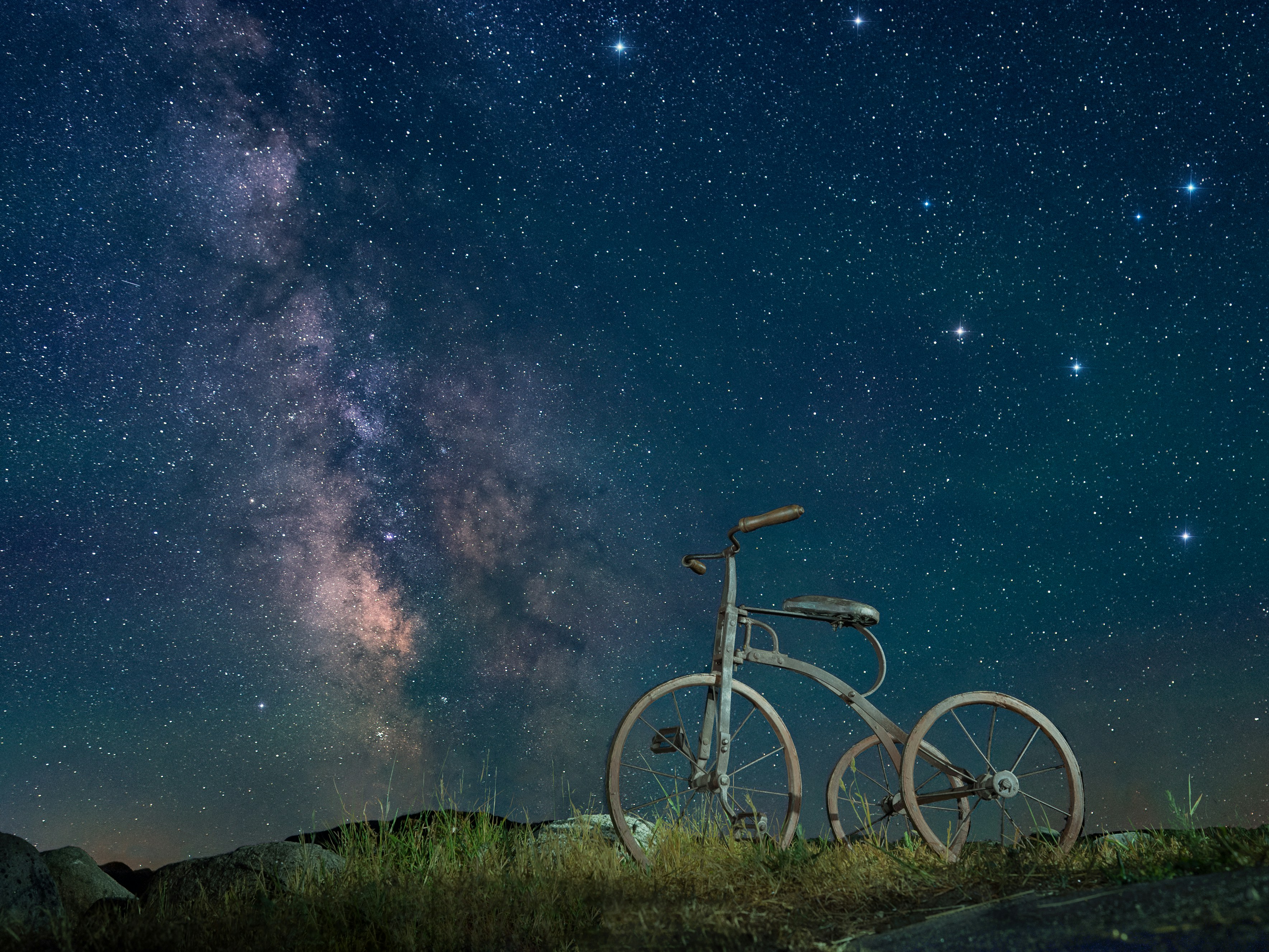Black commuter bike on green grass field under starry night photo ...