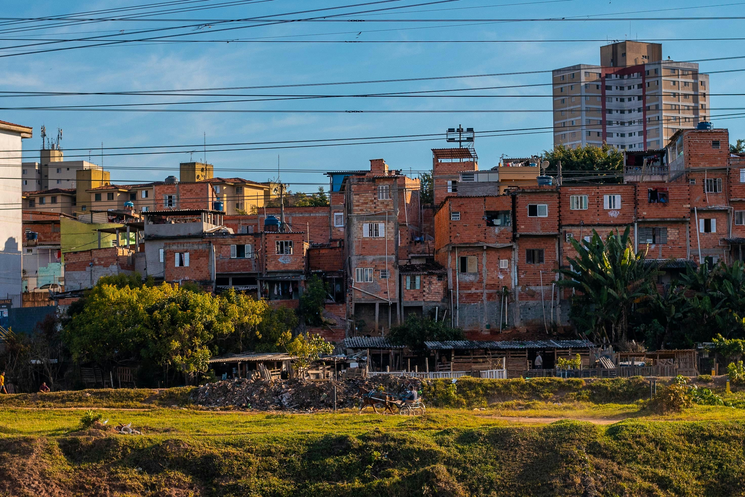 Cluster of colorful residential buildings bordered by a grassy field under a blue sky.