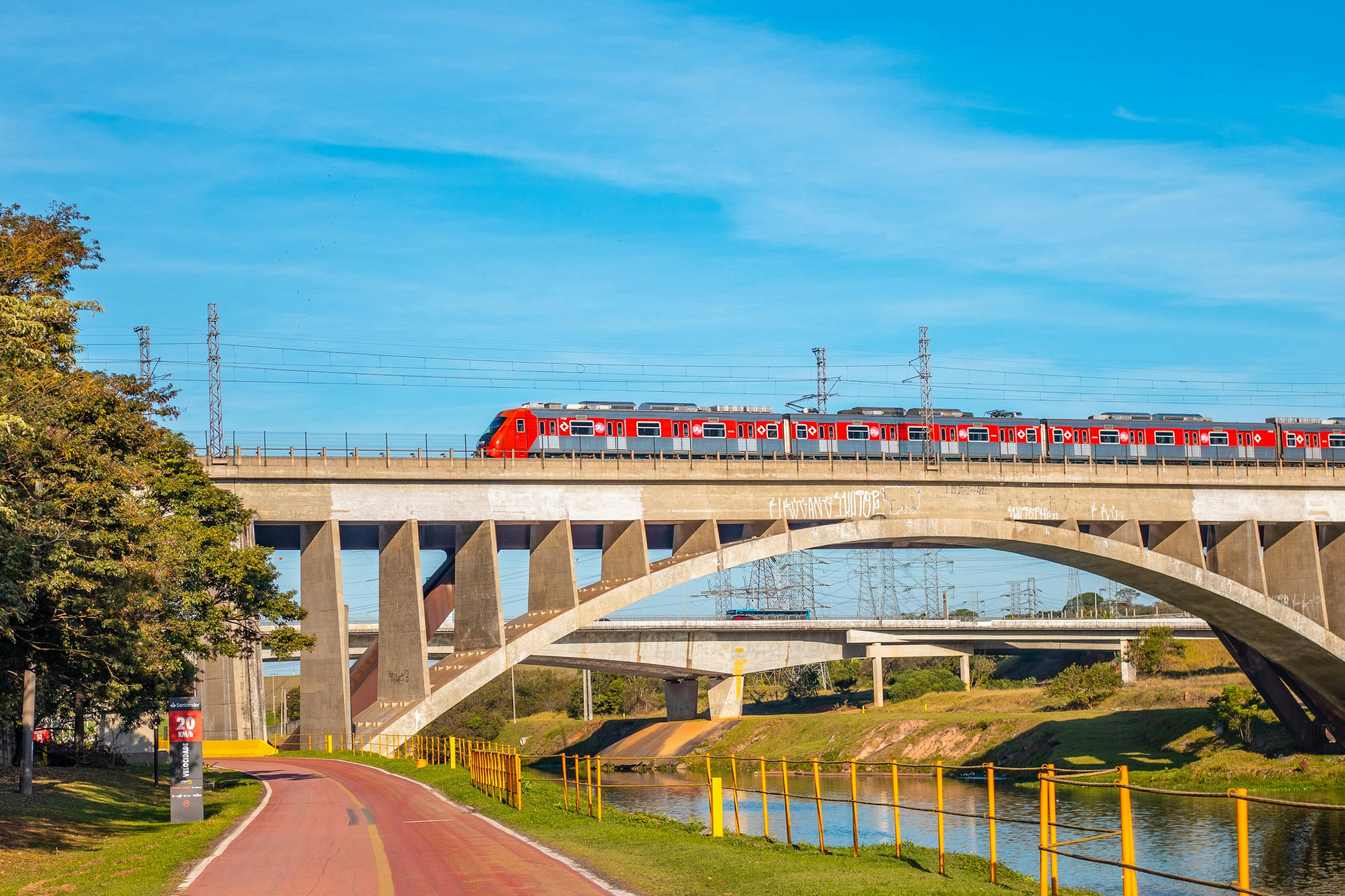 Red car on gray concrete bridge under blue sky during daytime photo ...
