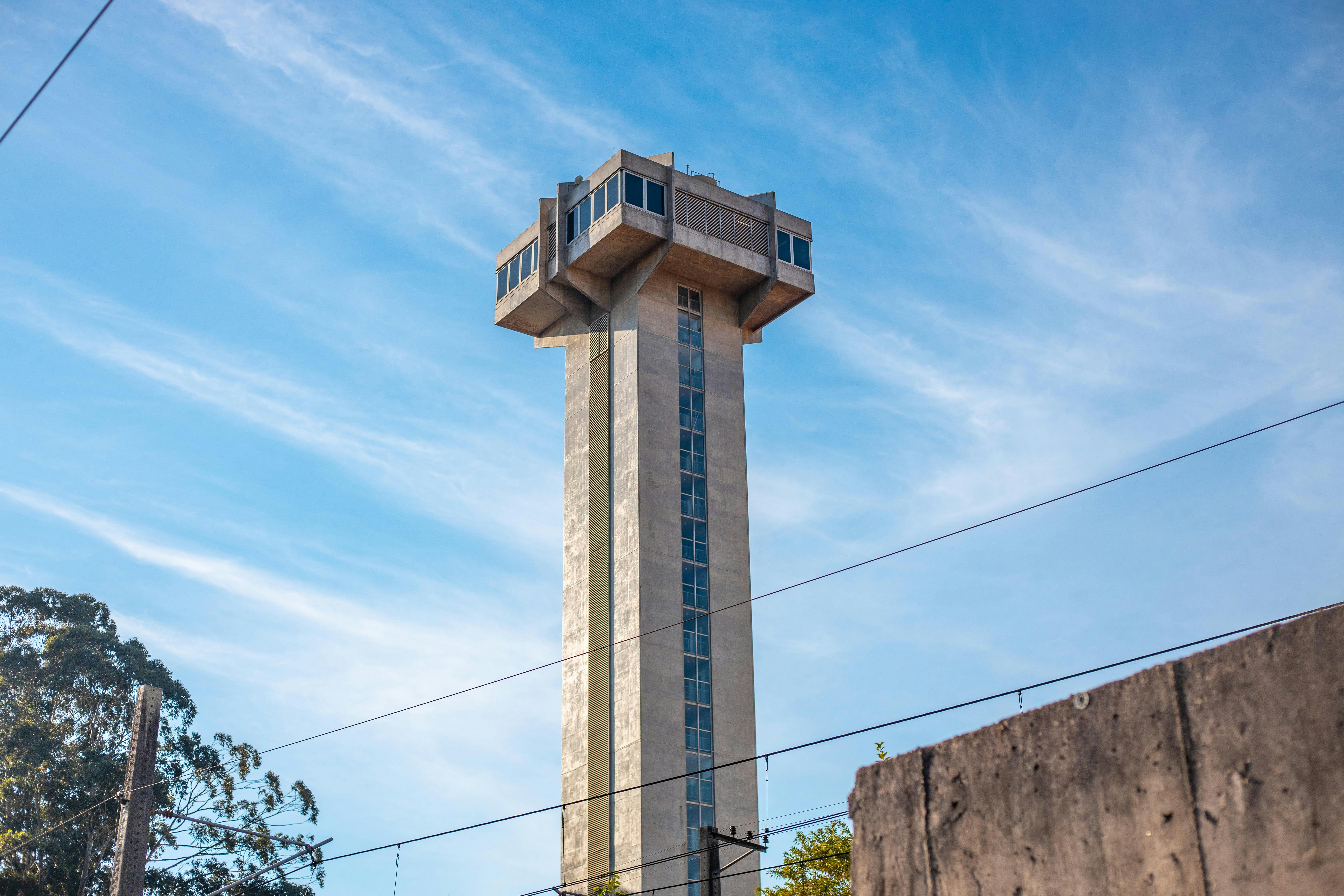 Skyward Observation Tower Rising Above a Quiet Wall
