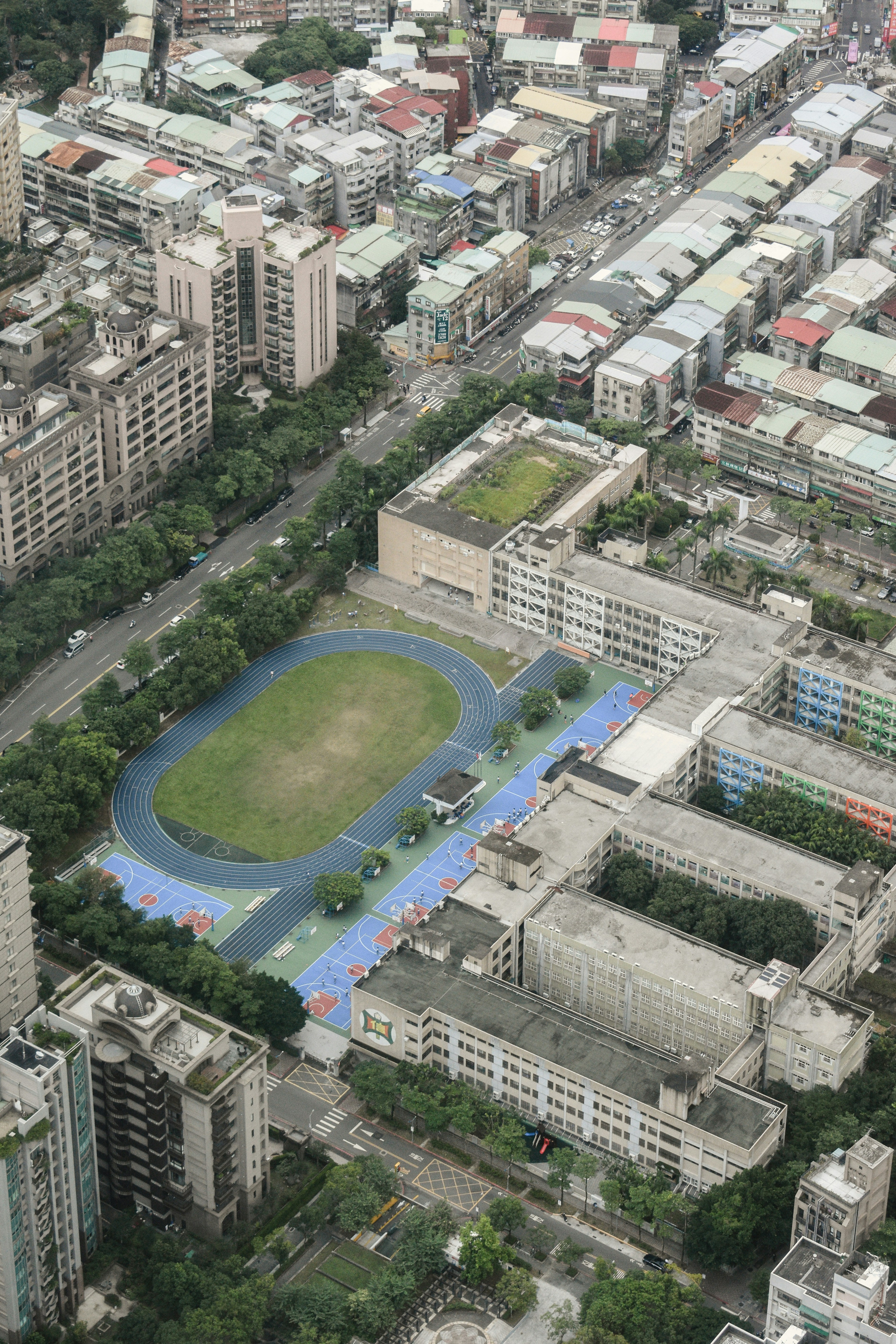 Blue Circuit in a Concrete Grid: An Aerial Portrait of an Urban Track Stadium