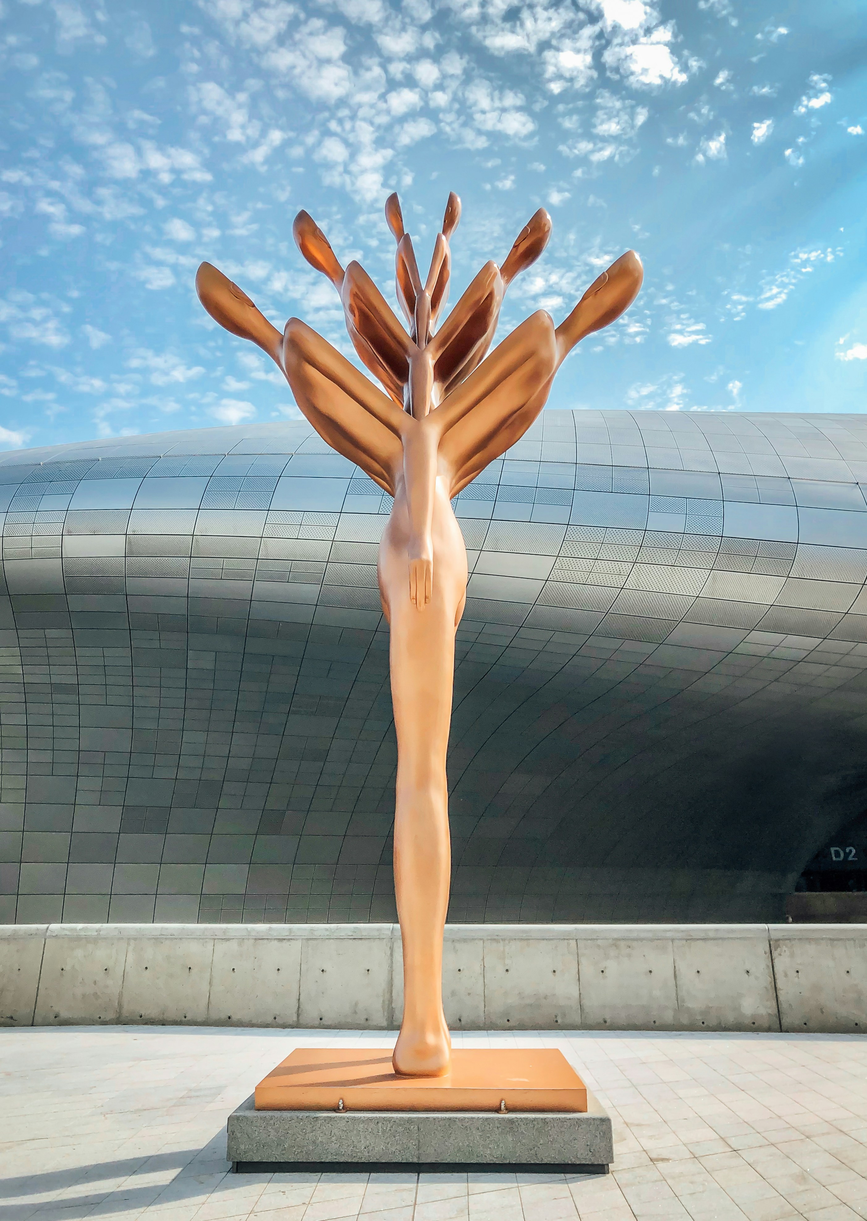 Ten Hands Toward the Sky: Bronze Gesture Before a Curved Steel Facade